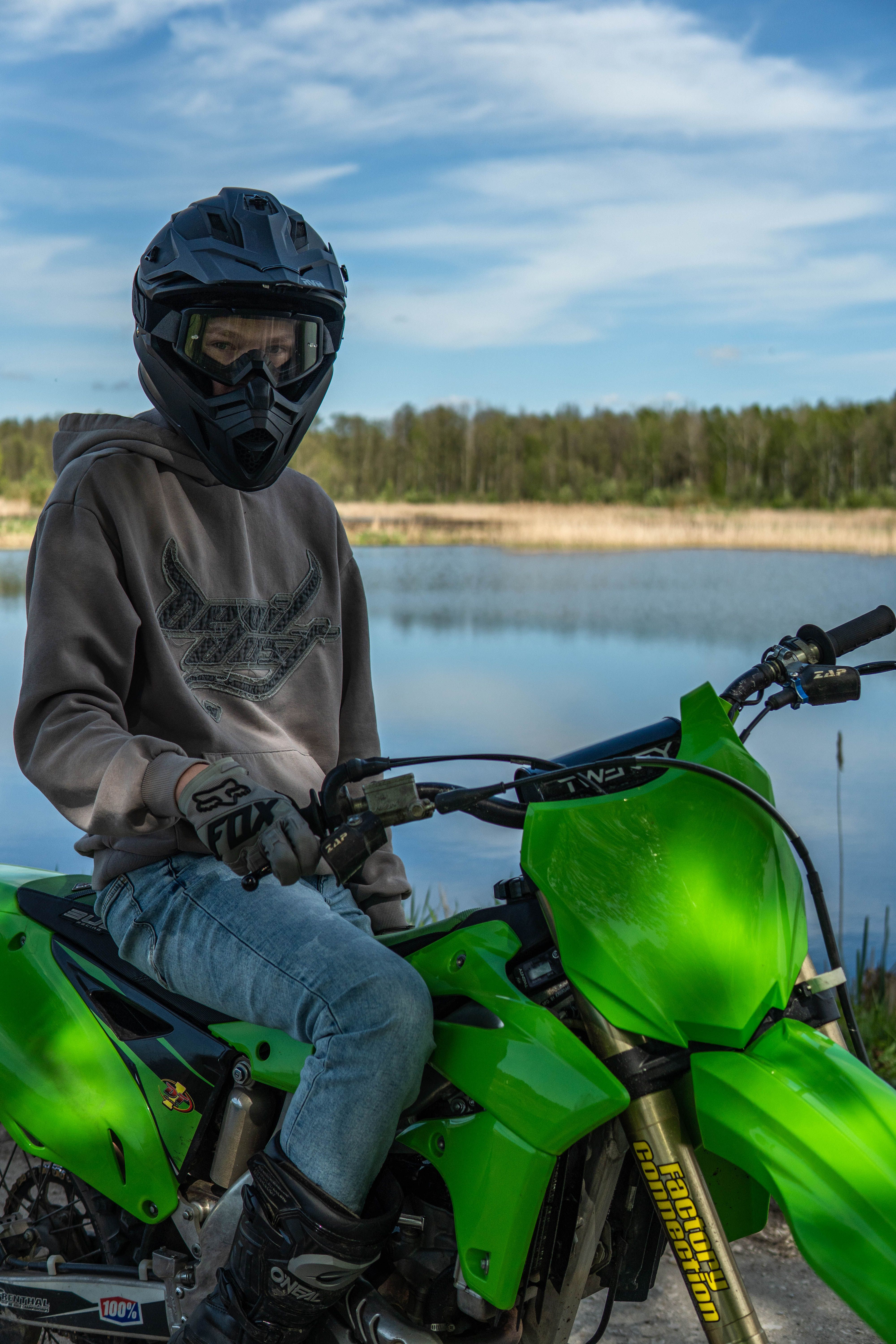 Teen Riding Green Dirt Bike by Scenic Lake · Free Stock Photo