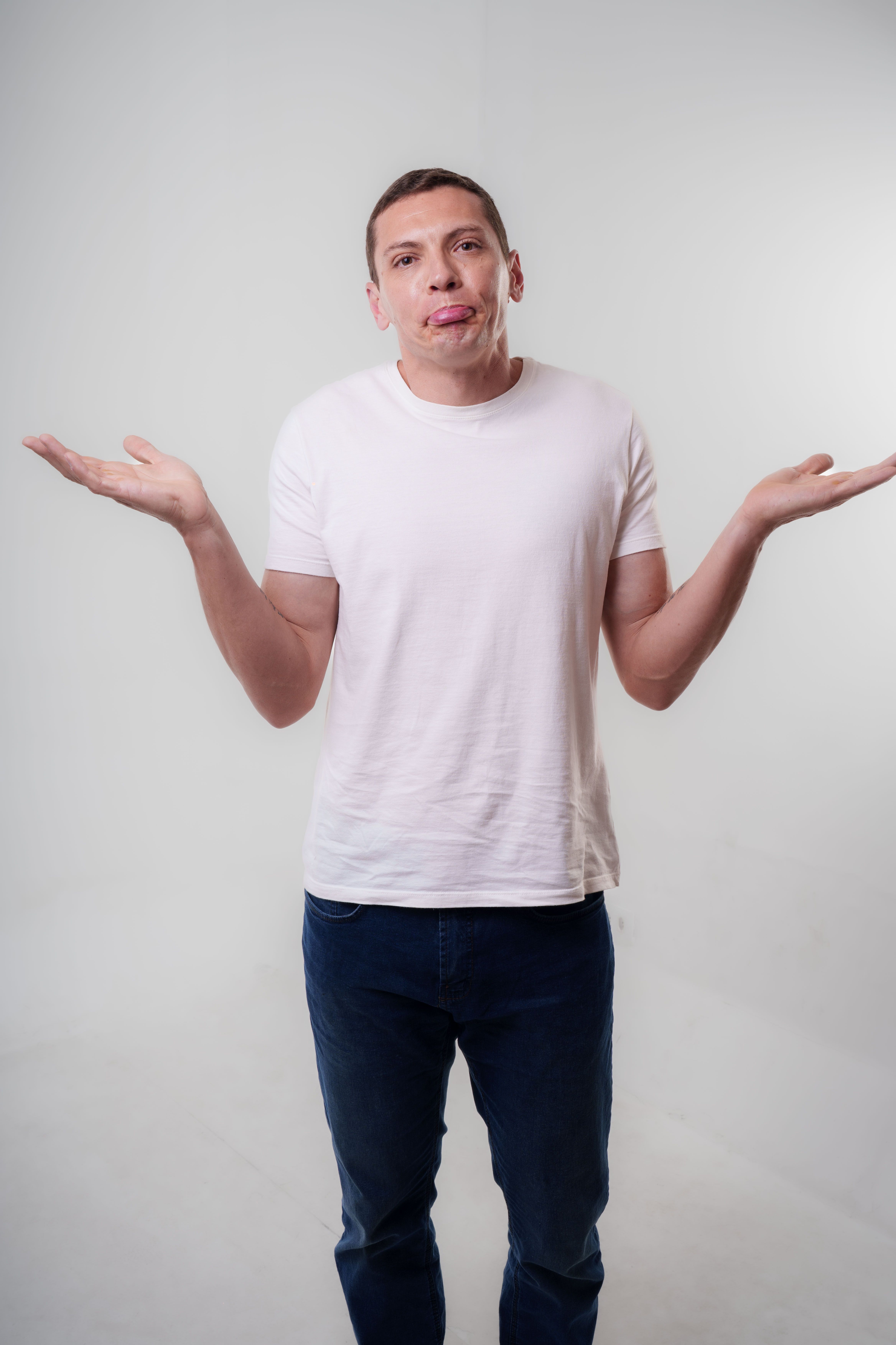Man Shrugging in Studio with Neutral Expression · Free Stock Photo