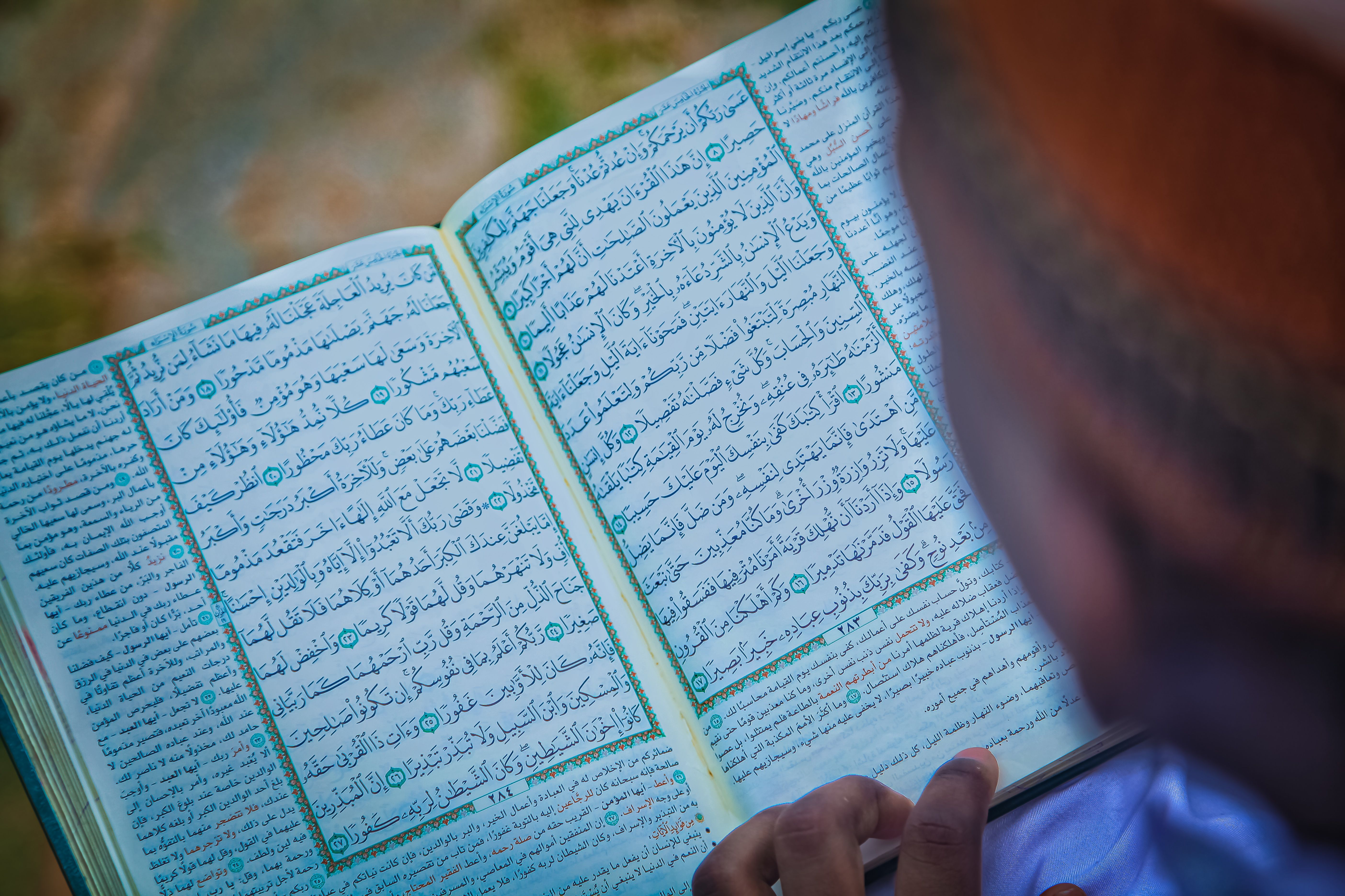Person Reading the Quran Outdoors · Free Stock Photo