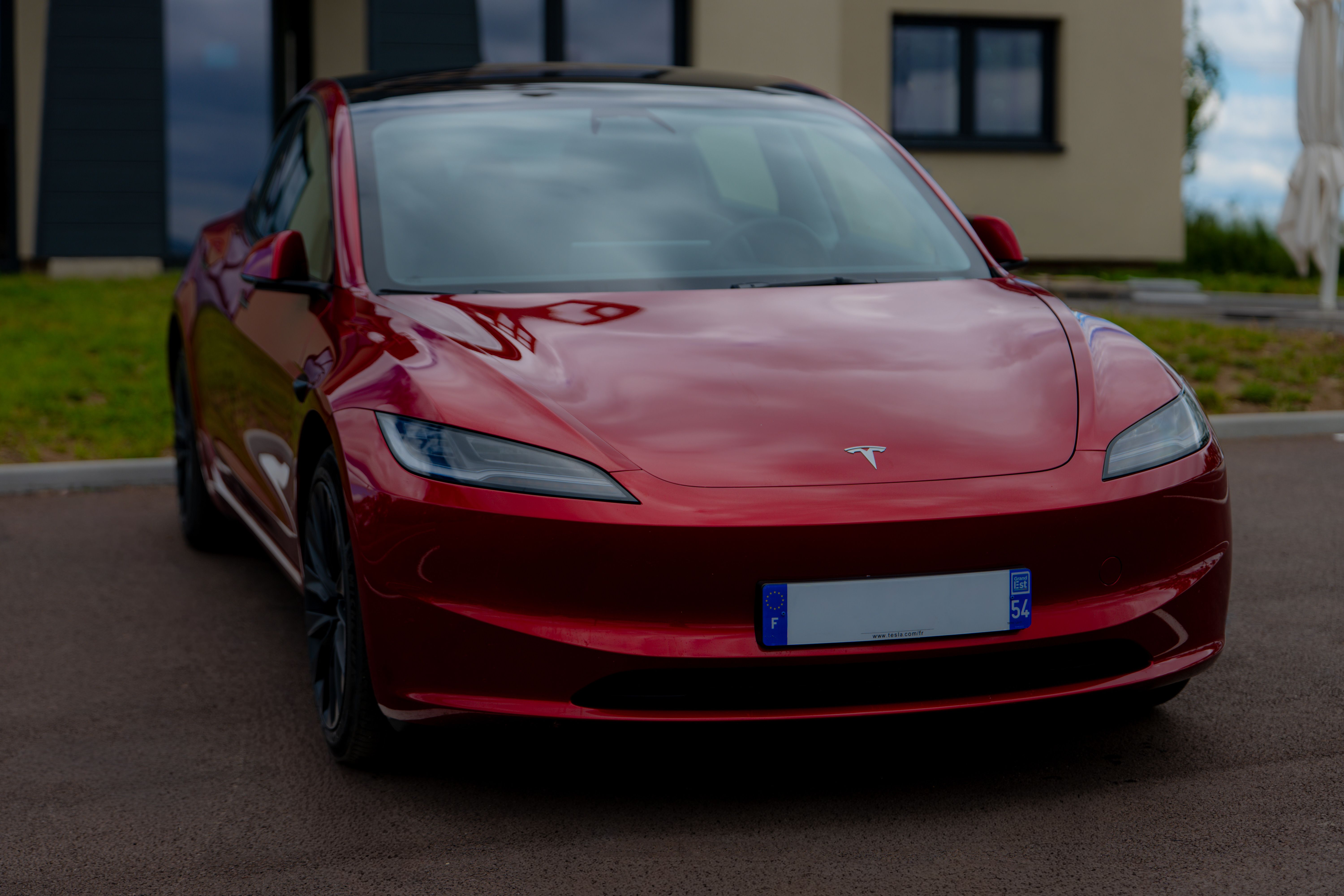 Sleek Red Electric Car Parked Outdoors · Free Stock Photo