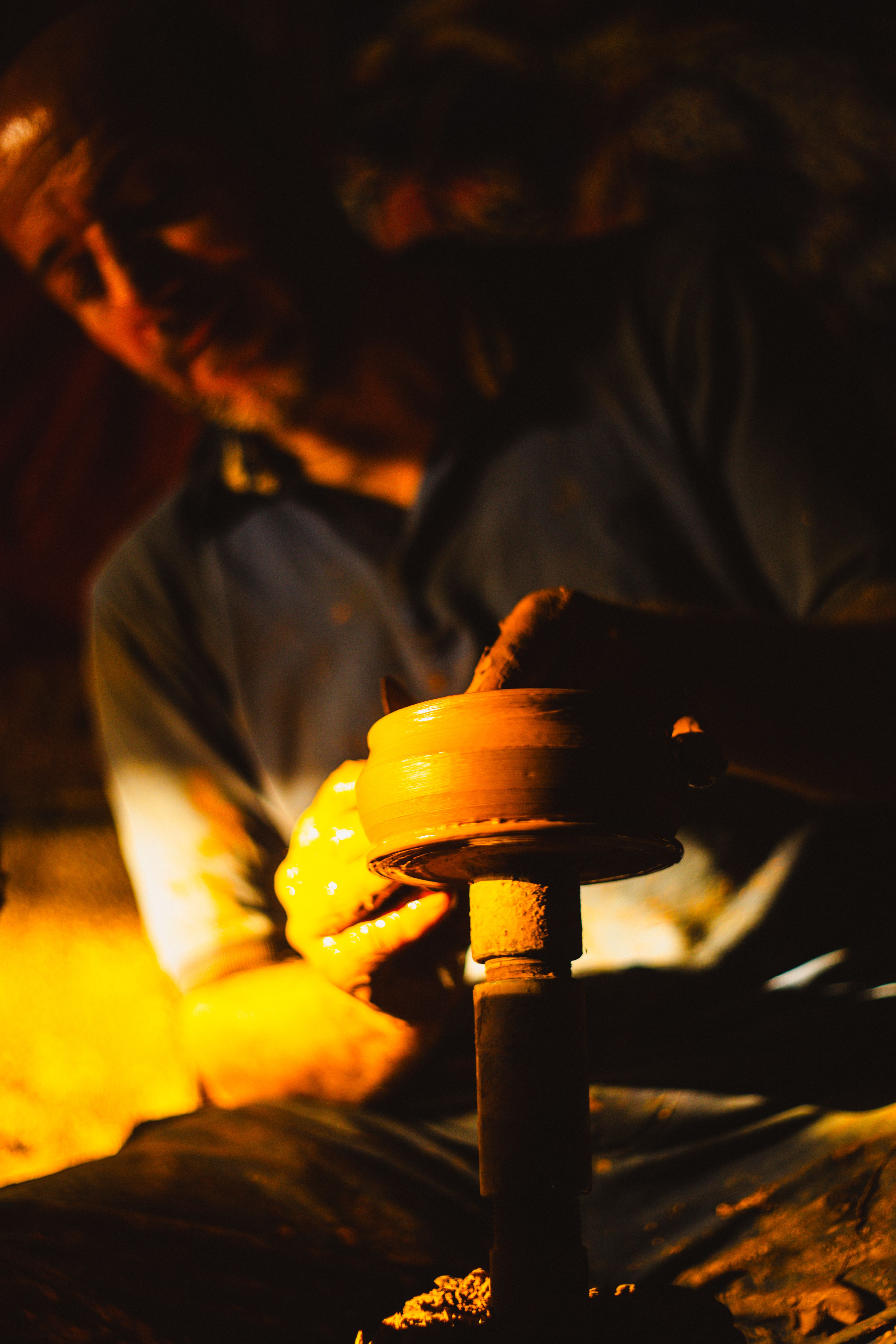 Traditional Pottery Craftsmanship in Warm Lighting · Free Stock Photo