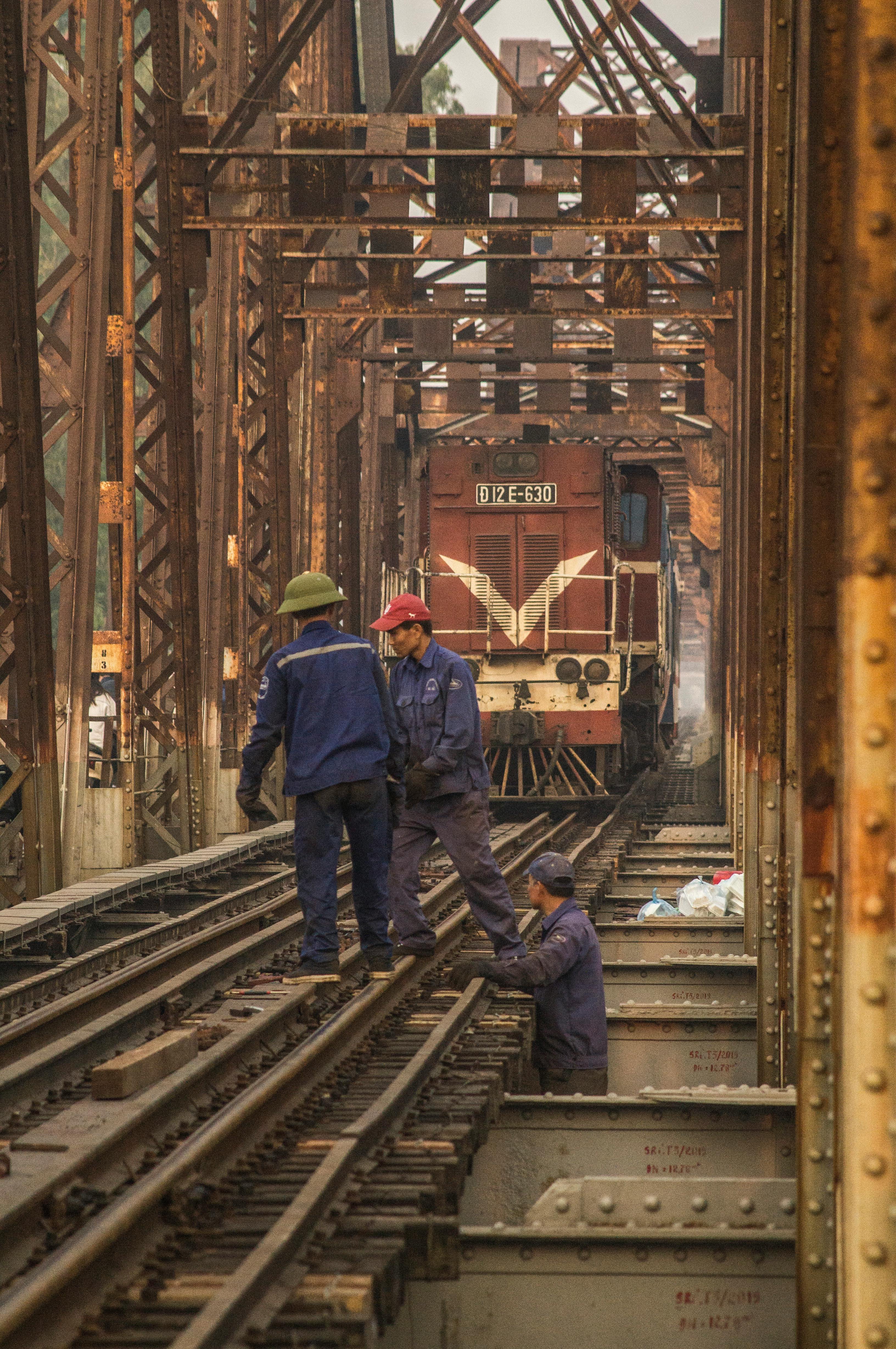 Anonymous men working on railway station · Free Stock Photo
