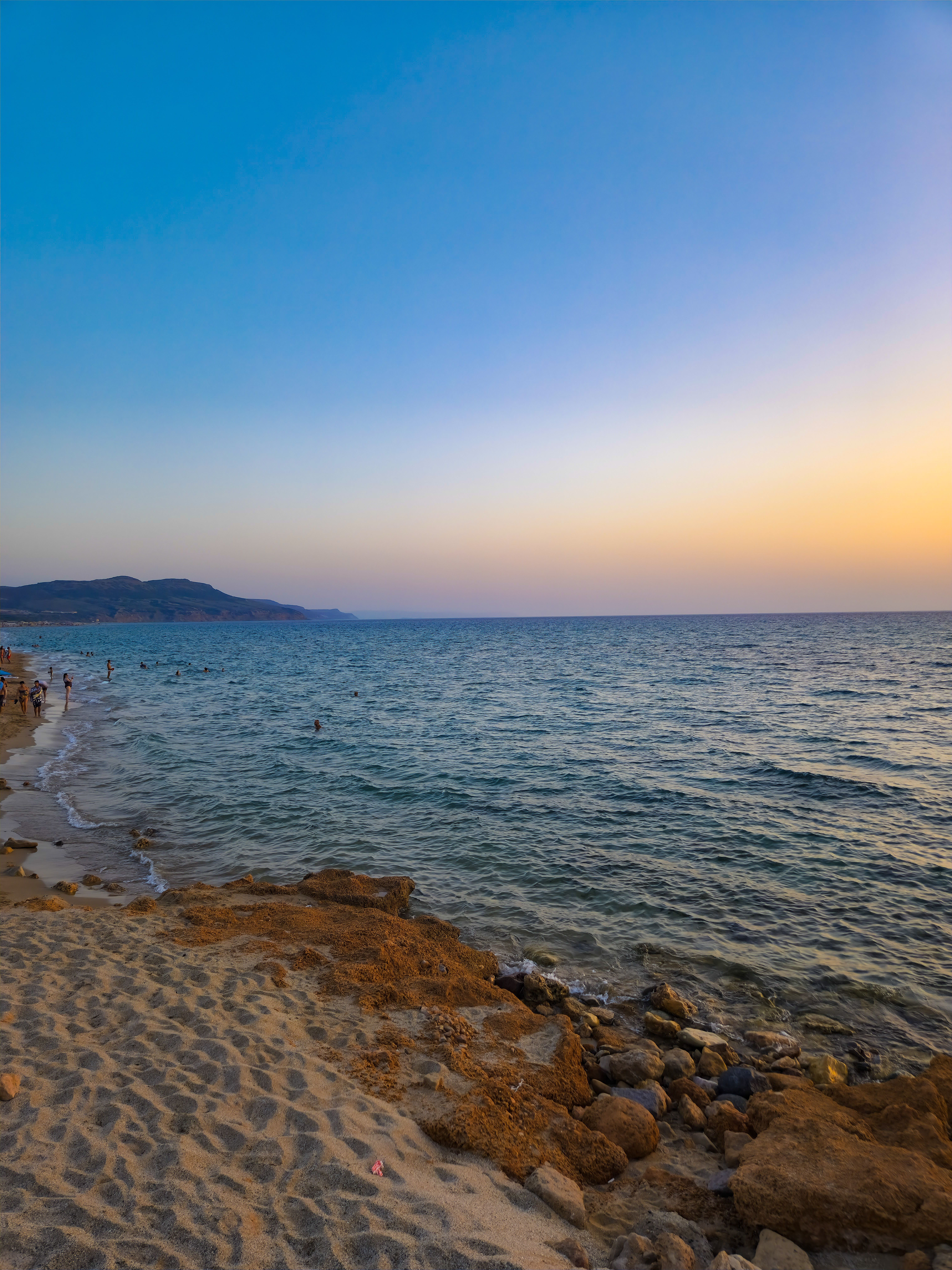 Sunset Over Scenic Beach with Calm Waves · Free Stock Photo