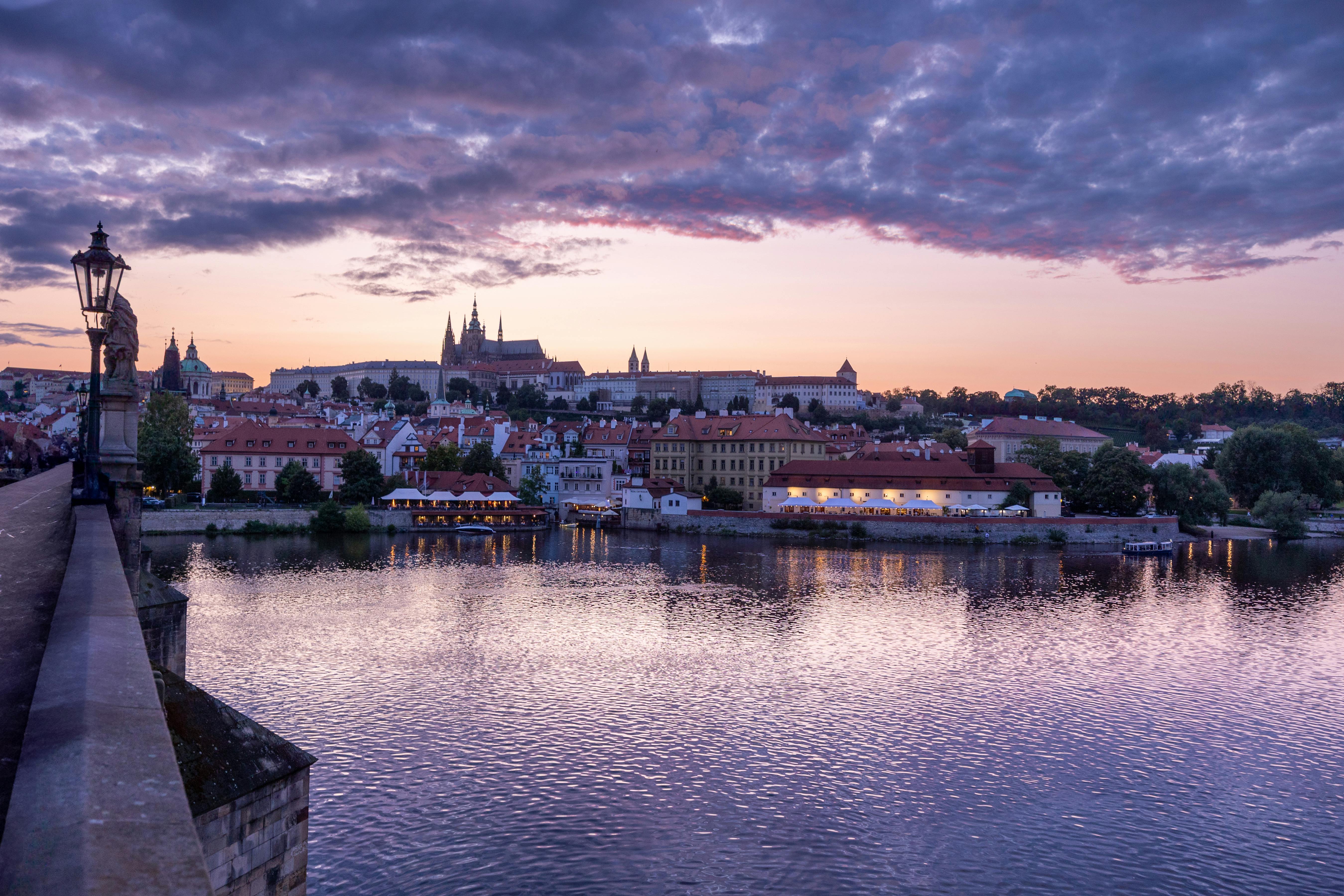 Vista Del Atardecer En Praga Con El Castillo Y El Río Reflejando ...