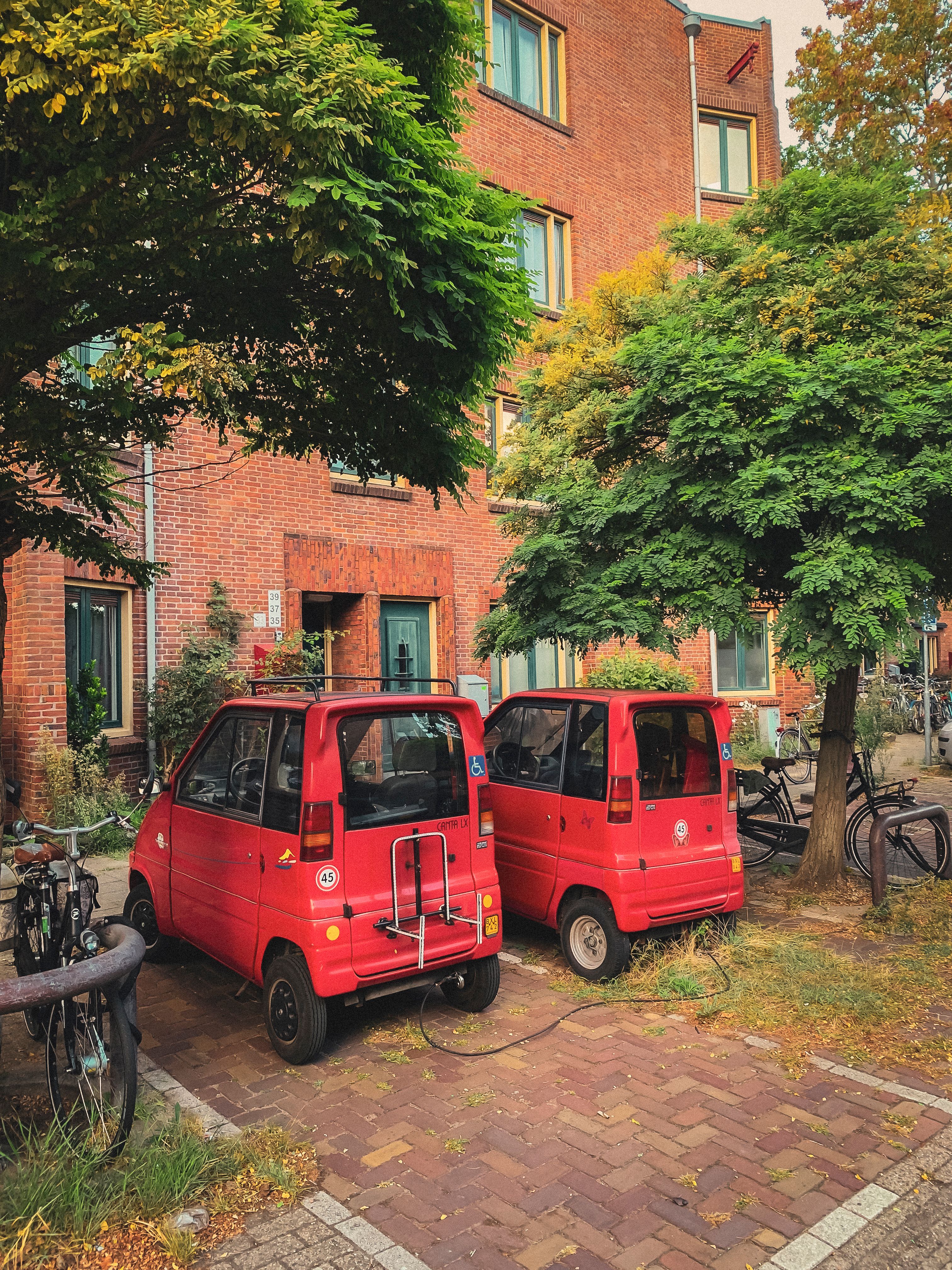 Charming Amsterdam Streets with Red Mini Cars · Free Stock Photo