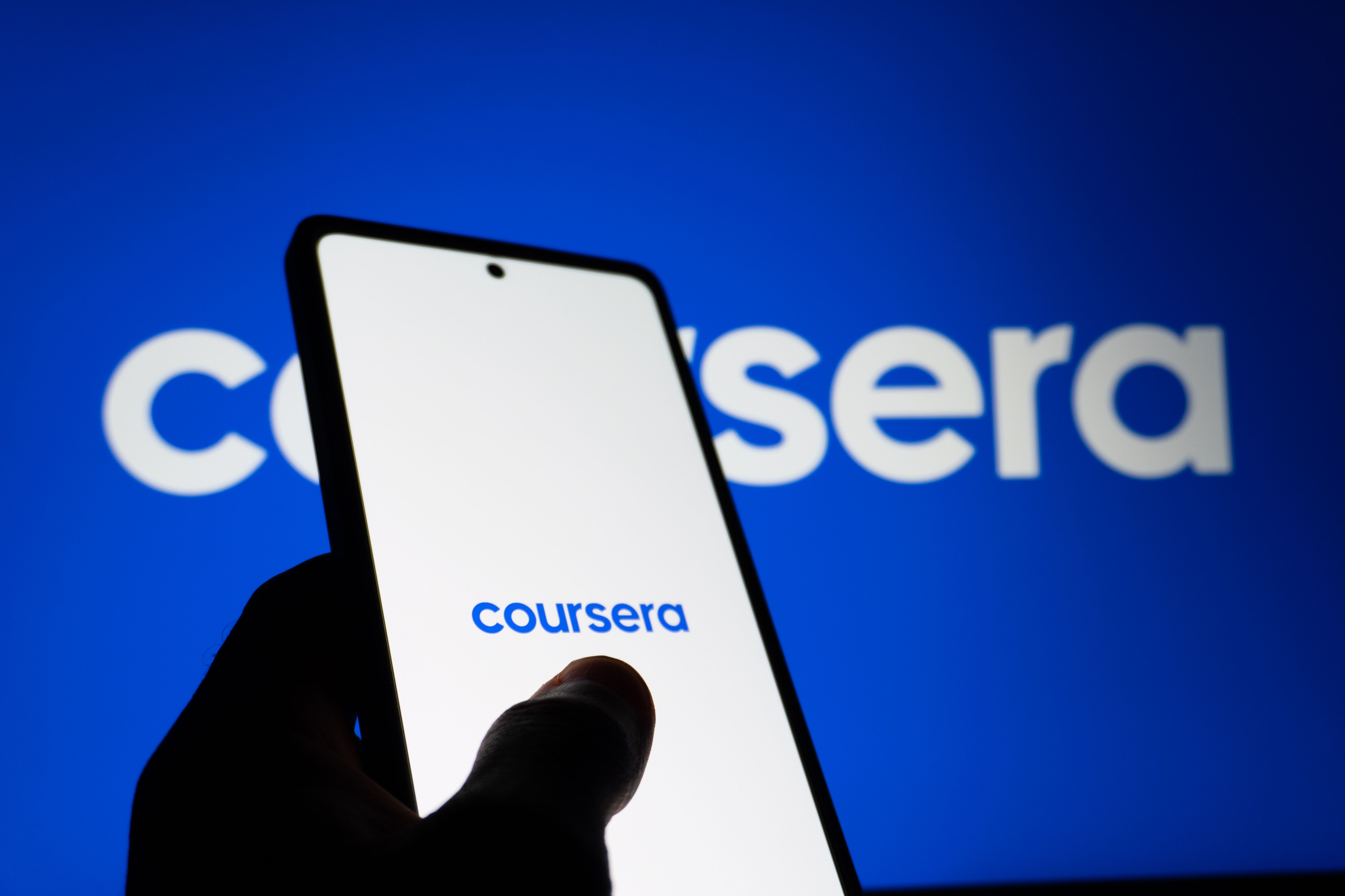 Smartphone Displaying Coursera Logo in Dark Room · Free Stock Photo
