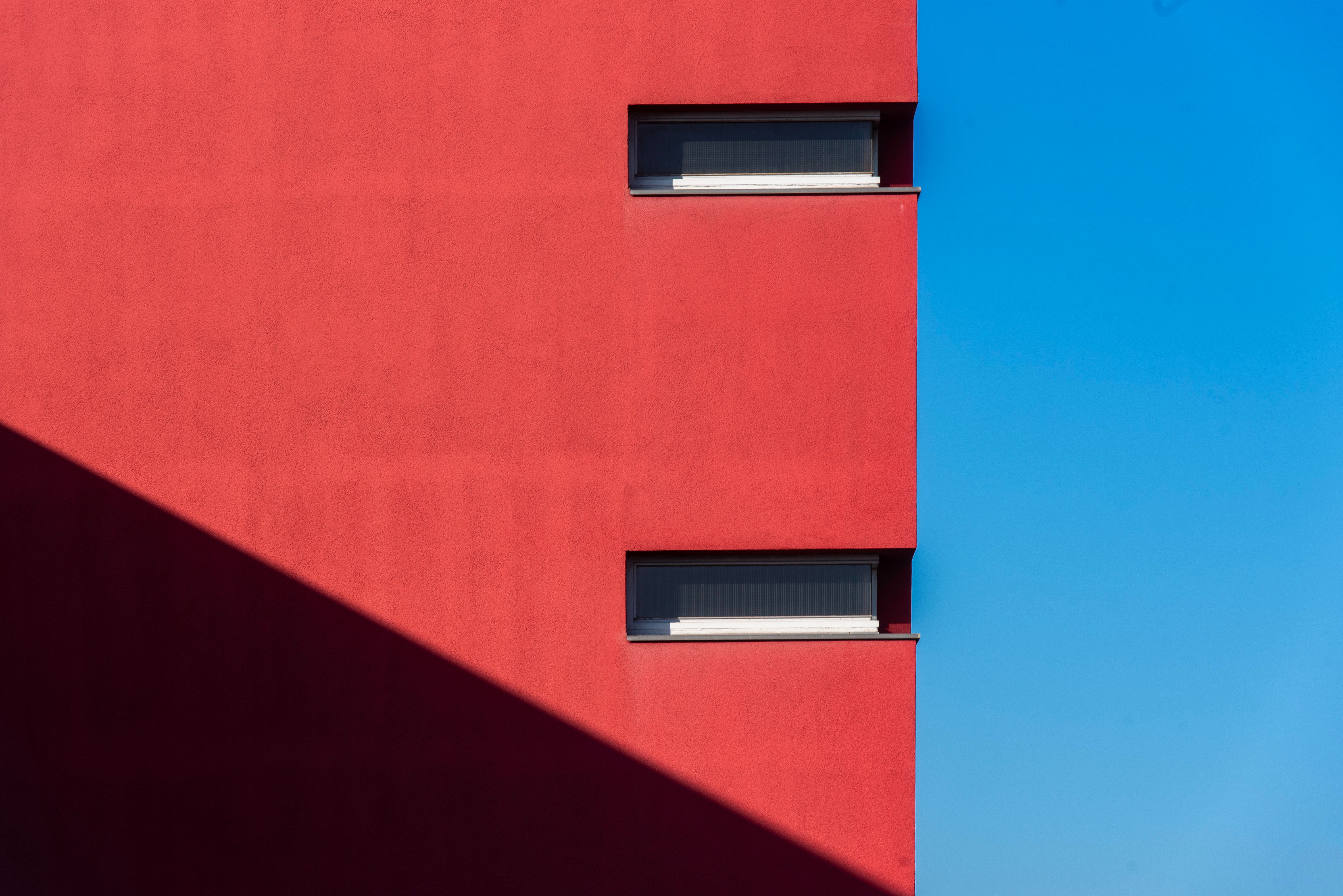 Bold Red Facade with Contrasting Blue Sky · Free Stock Photo