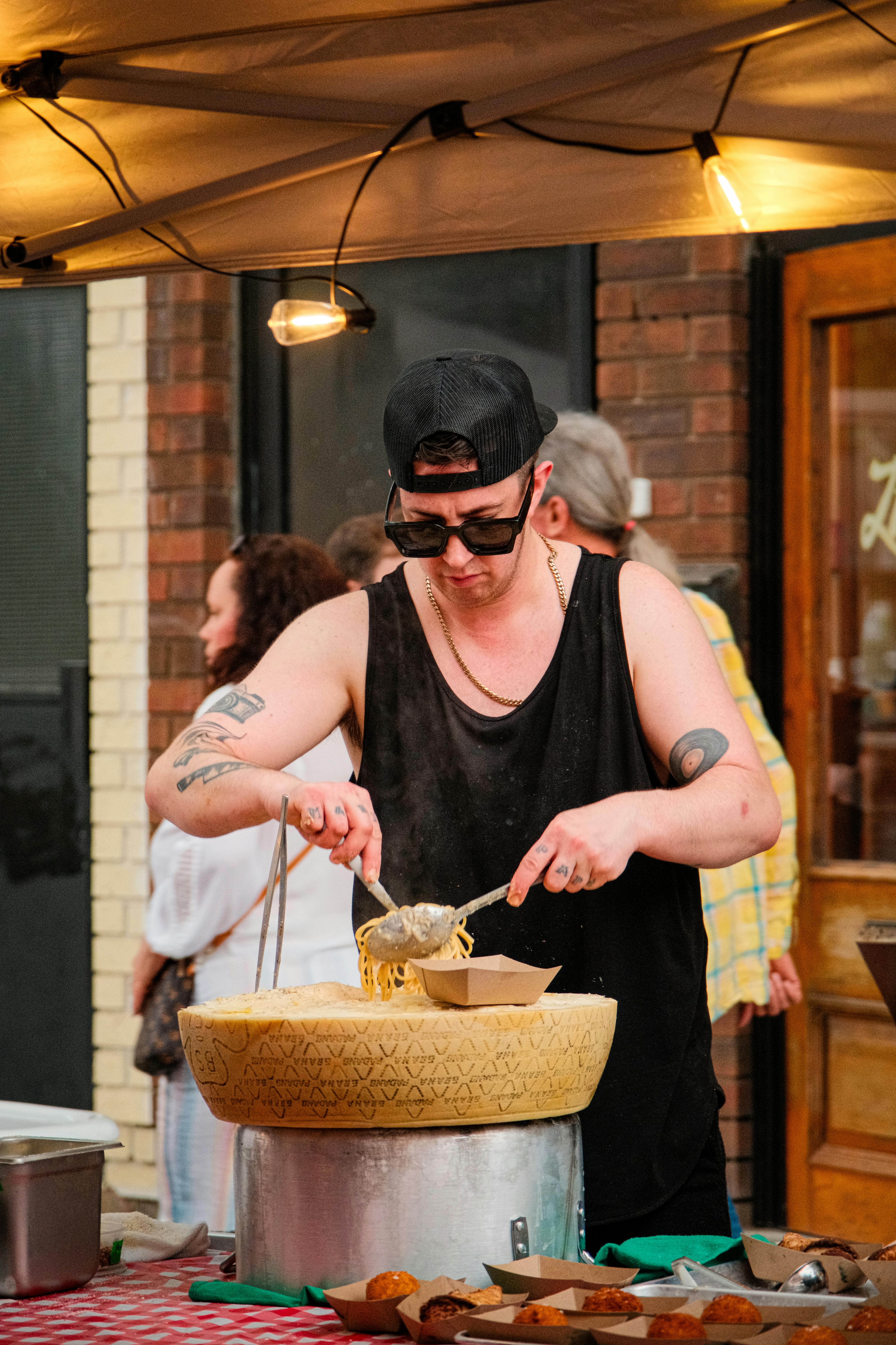 Street Chef Serving Pasta from Cheese Wheel · Free Stock Photo