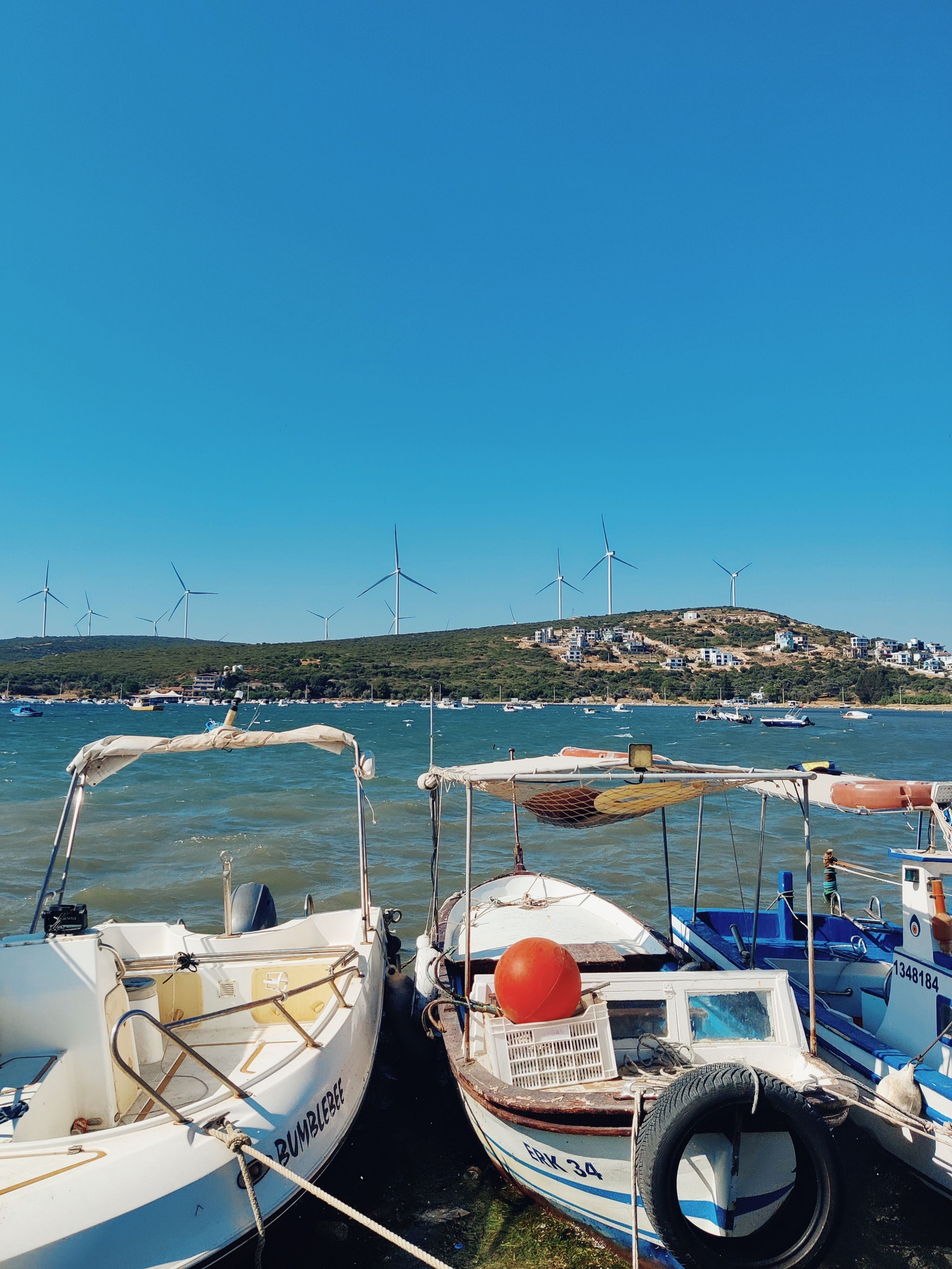 Scenic View of Boats and Wind Turbines by the Sea · Free Stock Photo