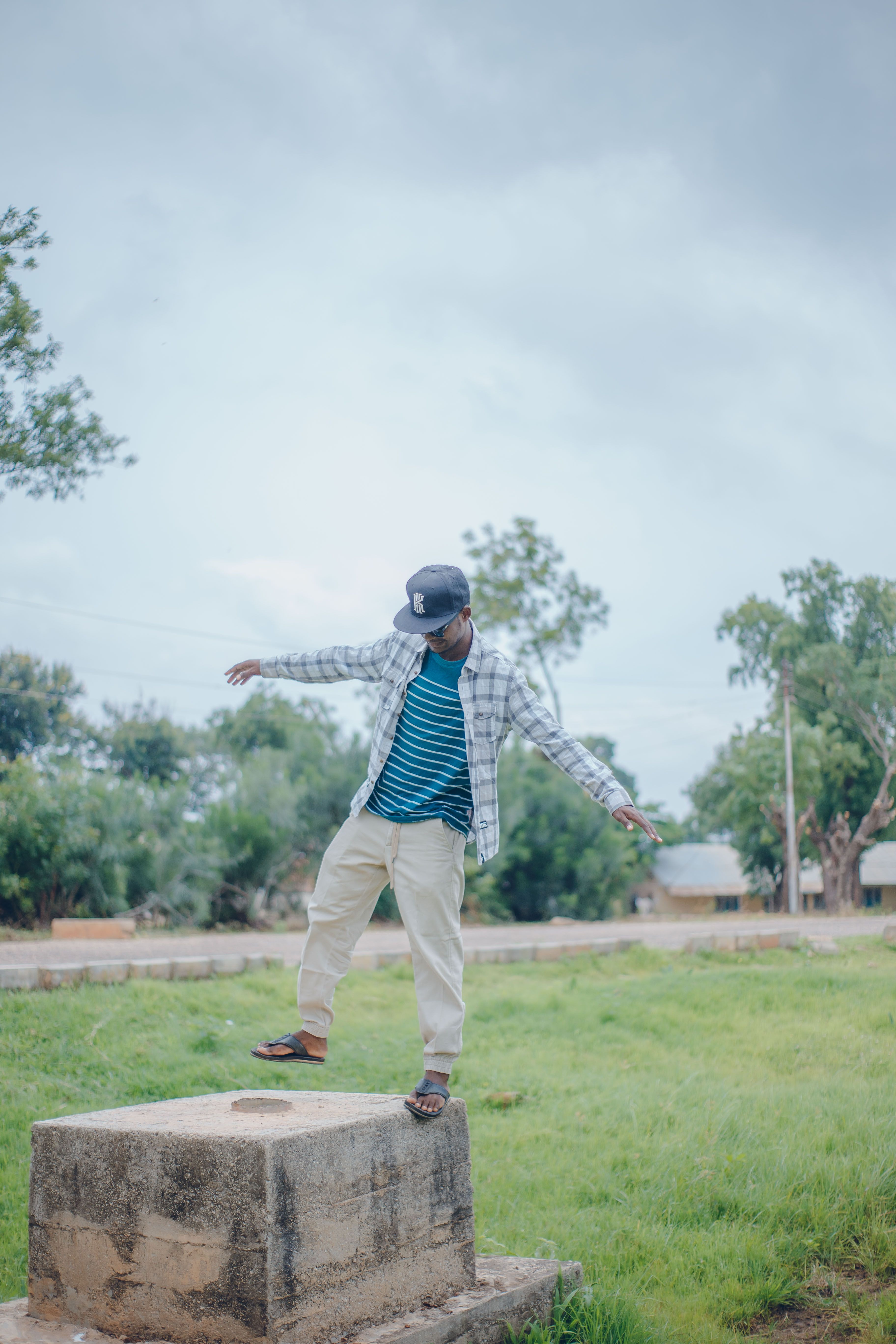Man Balances on Concrete Block in Park Setting · Free Stock Photo