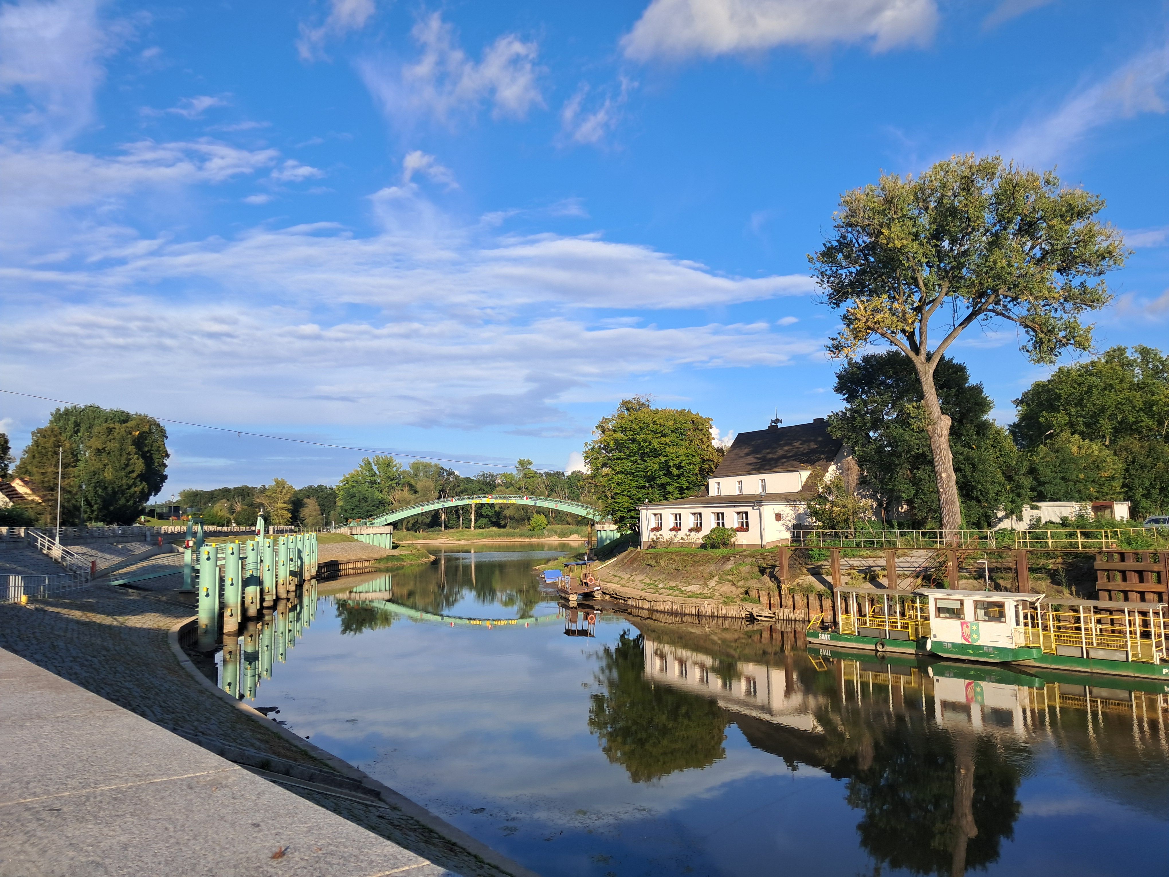 Tranquil Riverside Scene with Bridge and Boats · Free Stock Photo