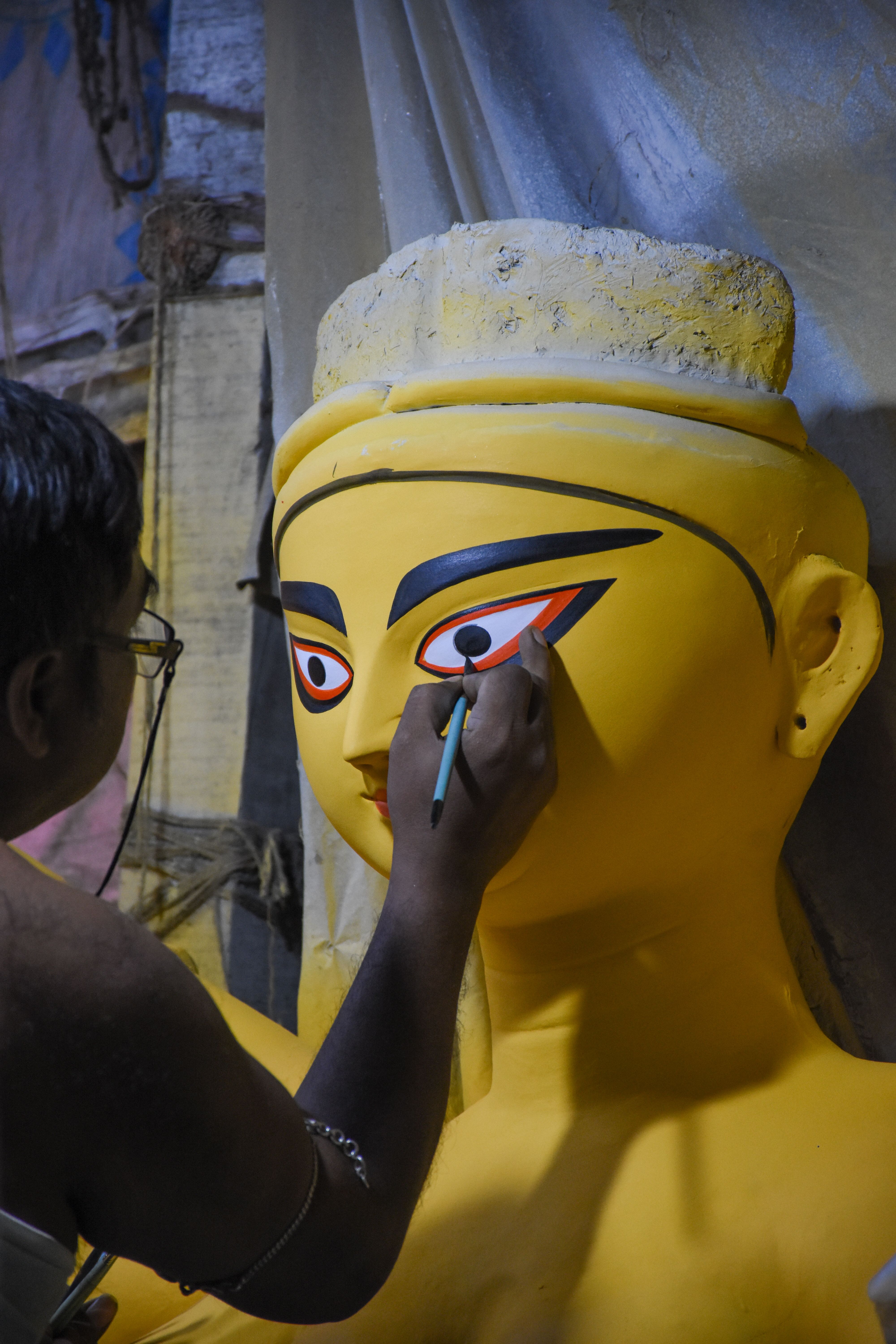 Artisan painting a clay idol in Kolkata workshop · Free Stock Photo