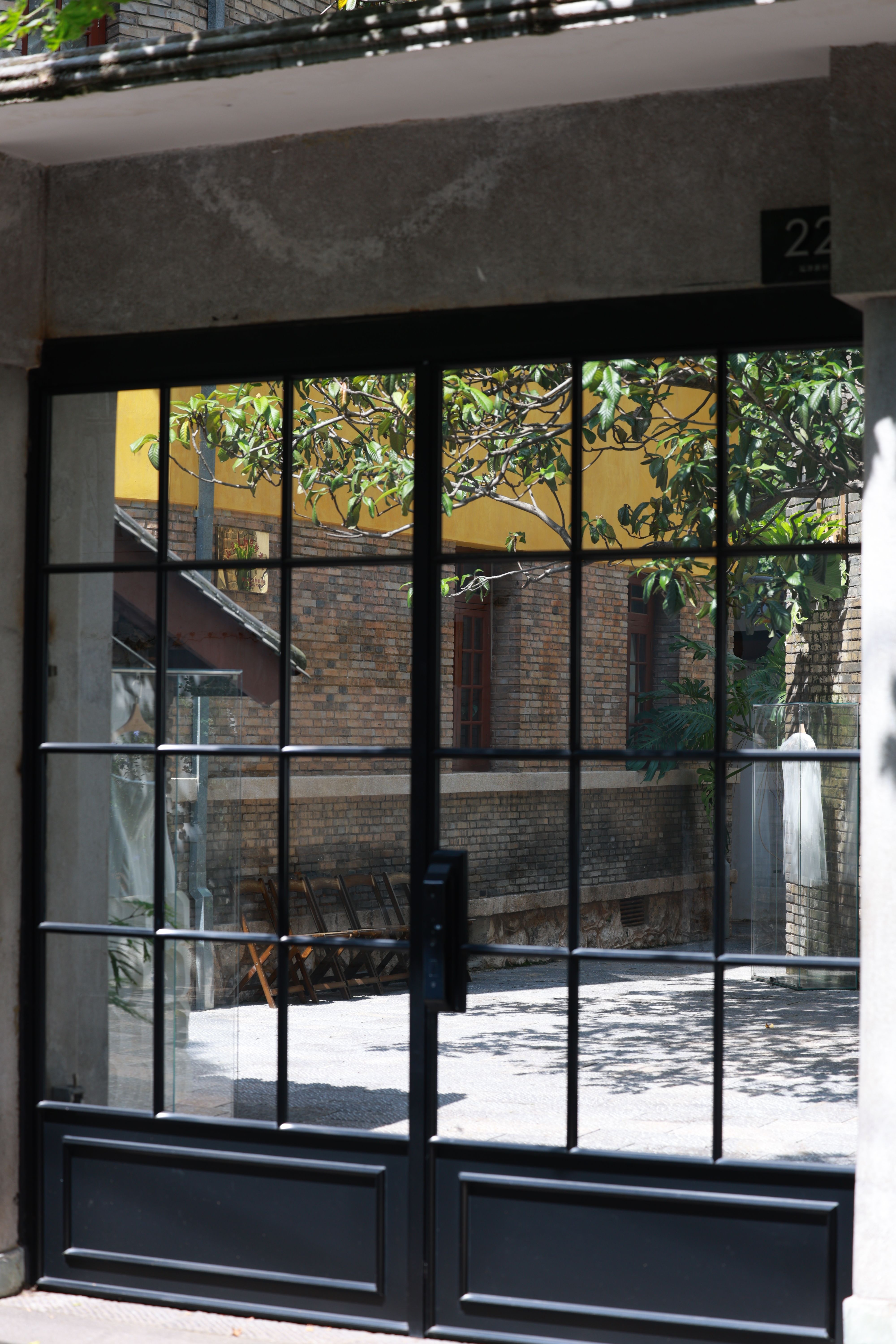 Reflection on Glass Door with Brick Architecture · Free Stock Photo