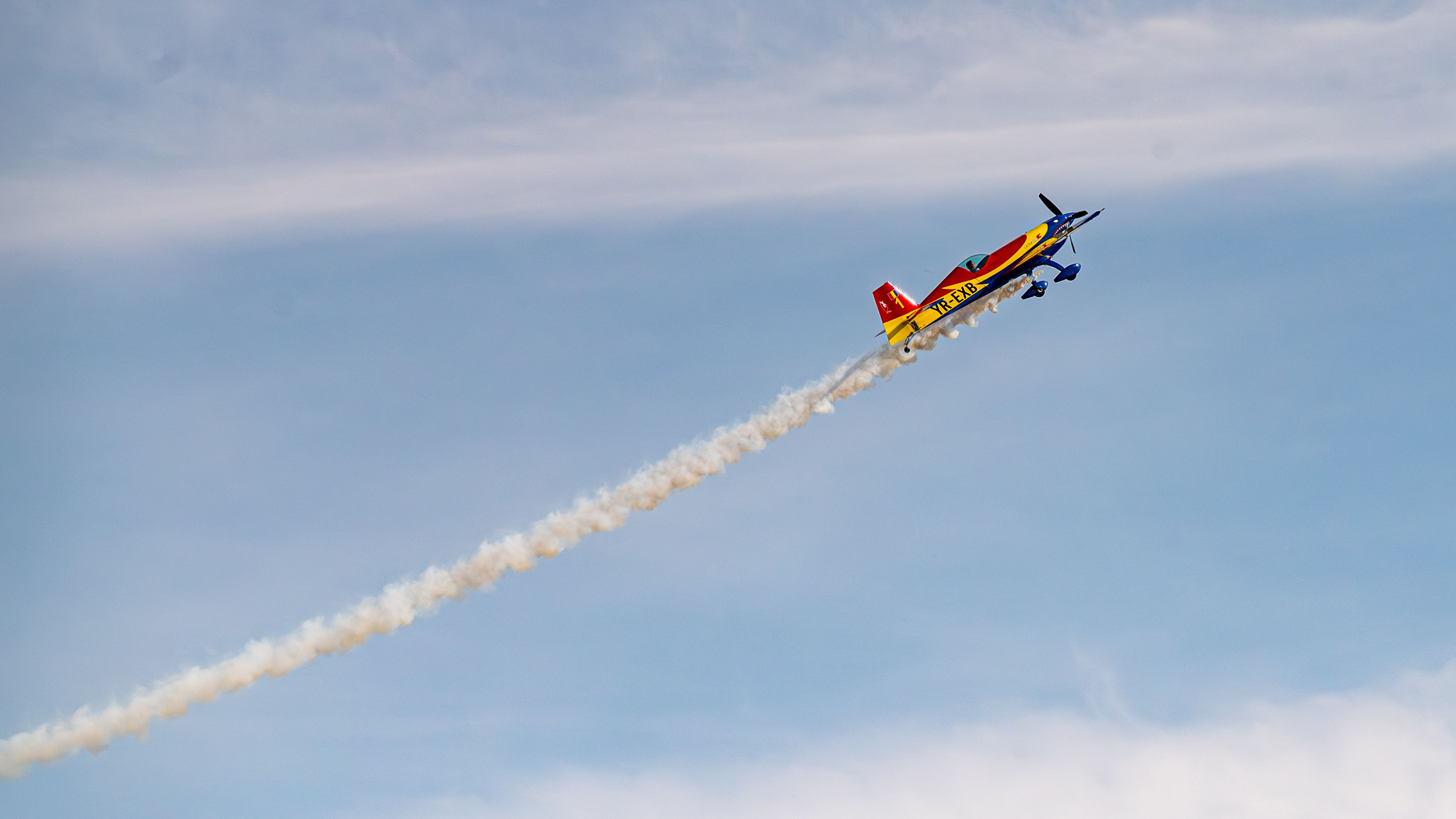 Dynamic Aerobatic Aircraft with Smoke Trail in Blue Sky · Free Stock Photo