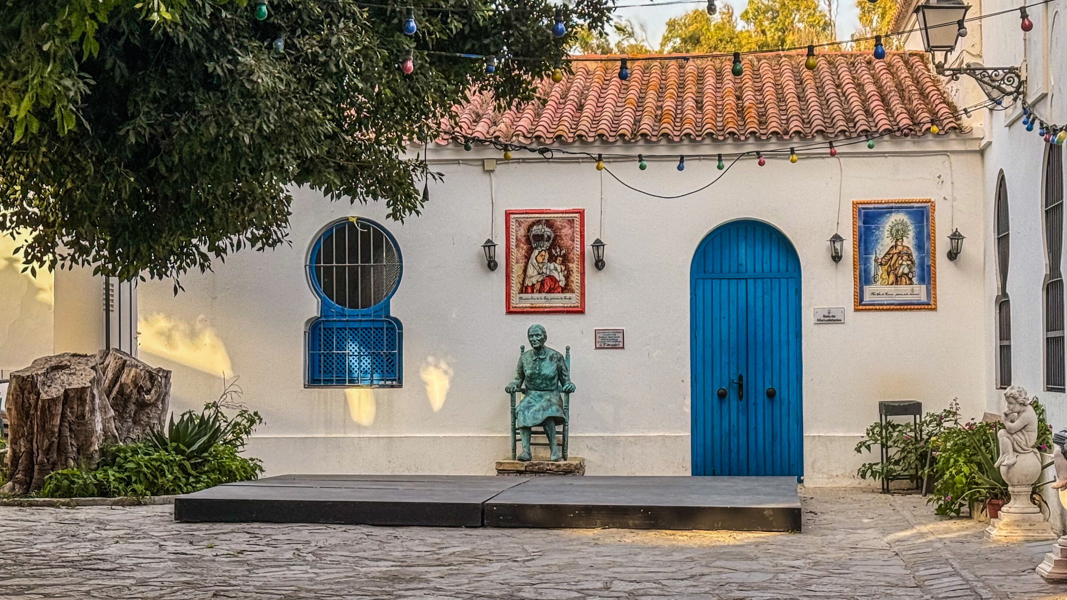 Charming Courtyard with Blue Door and Statues · Free Stock Photo