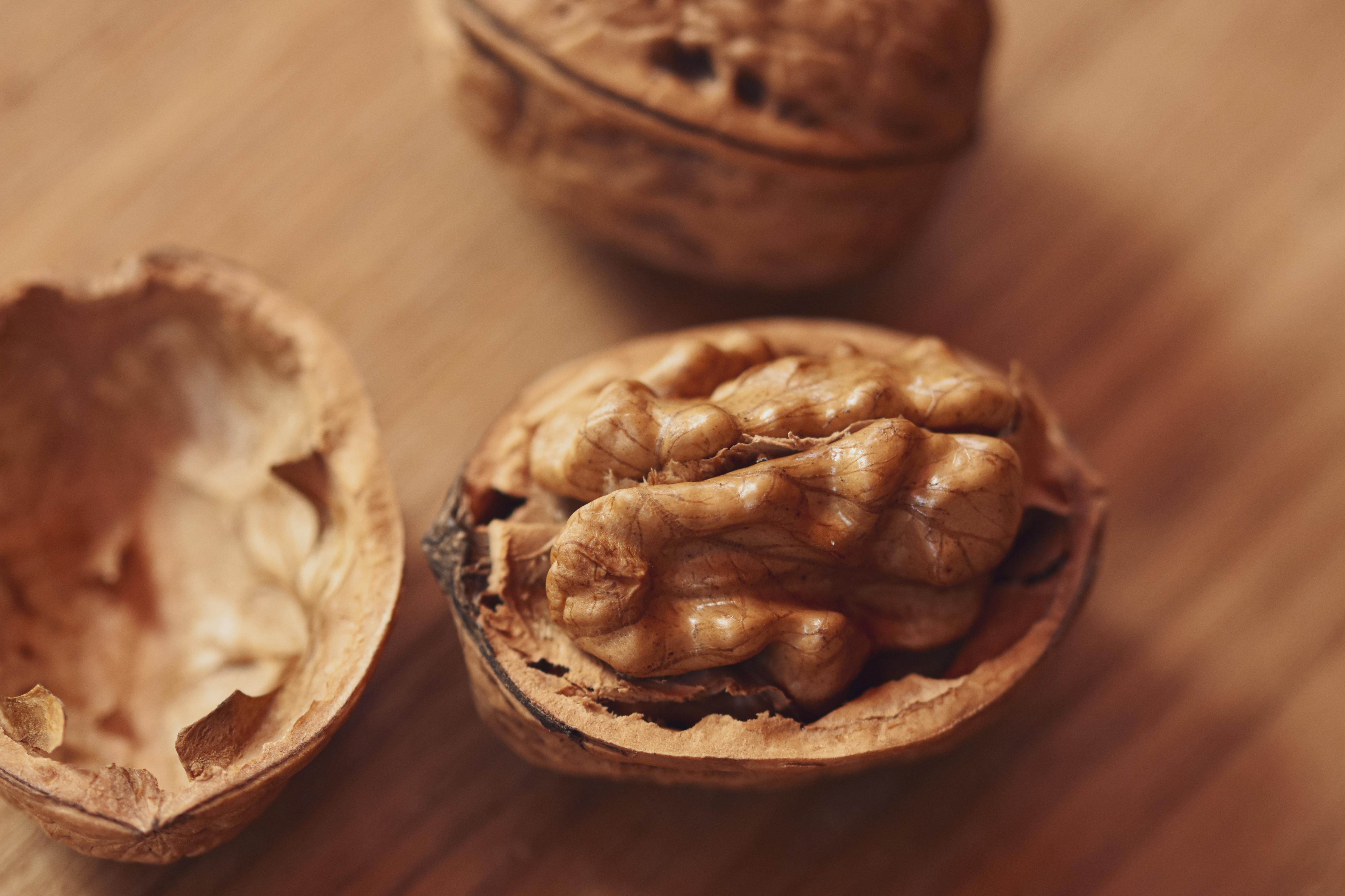 Close-up of Walnut in Shell on Wooden Surface · Free Stock Photo
