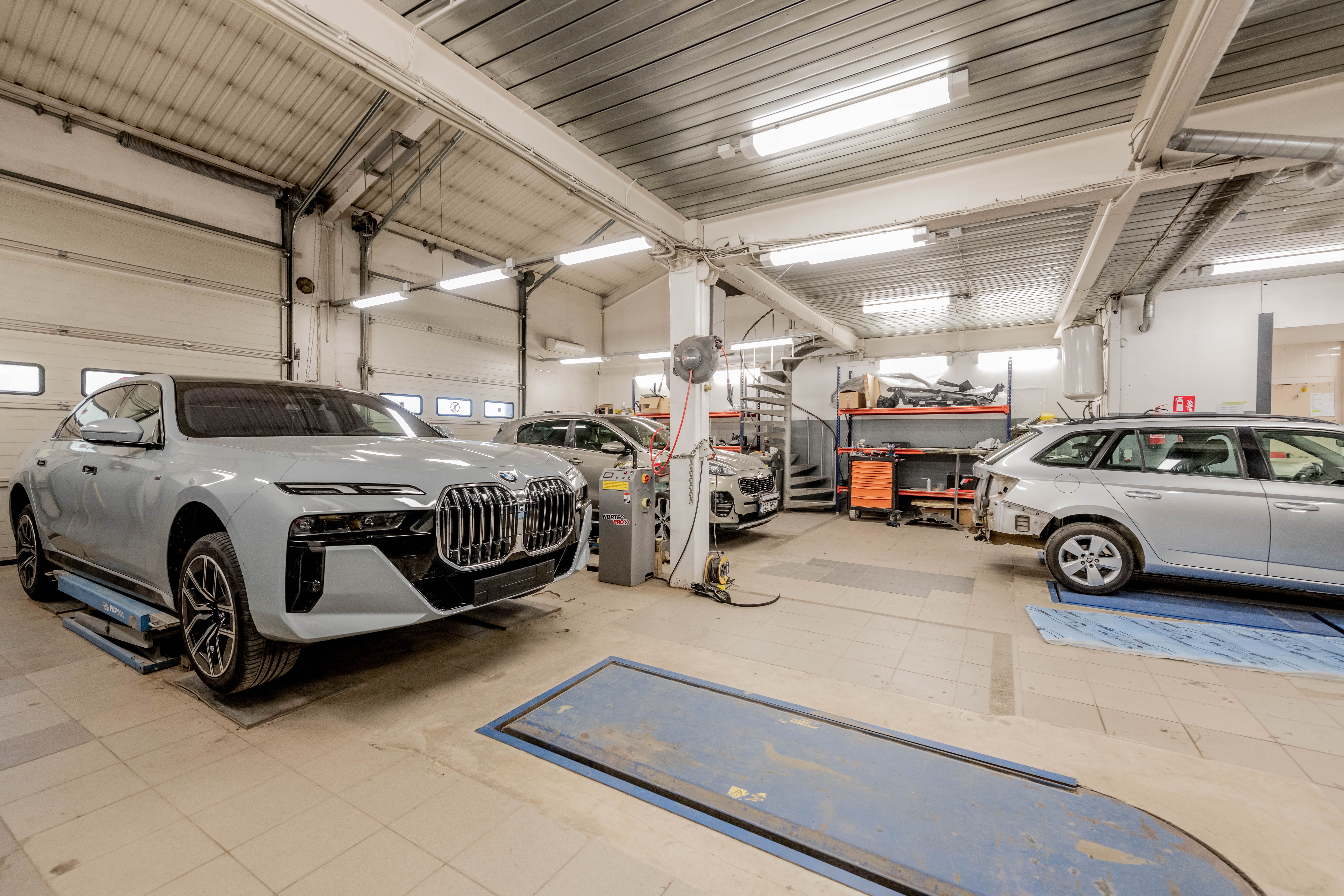Modern Car Service Garage with Luxury Vehicles · Free Stock Photo