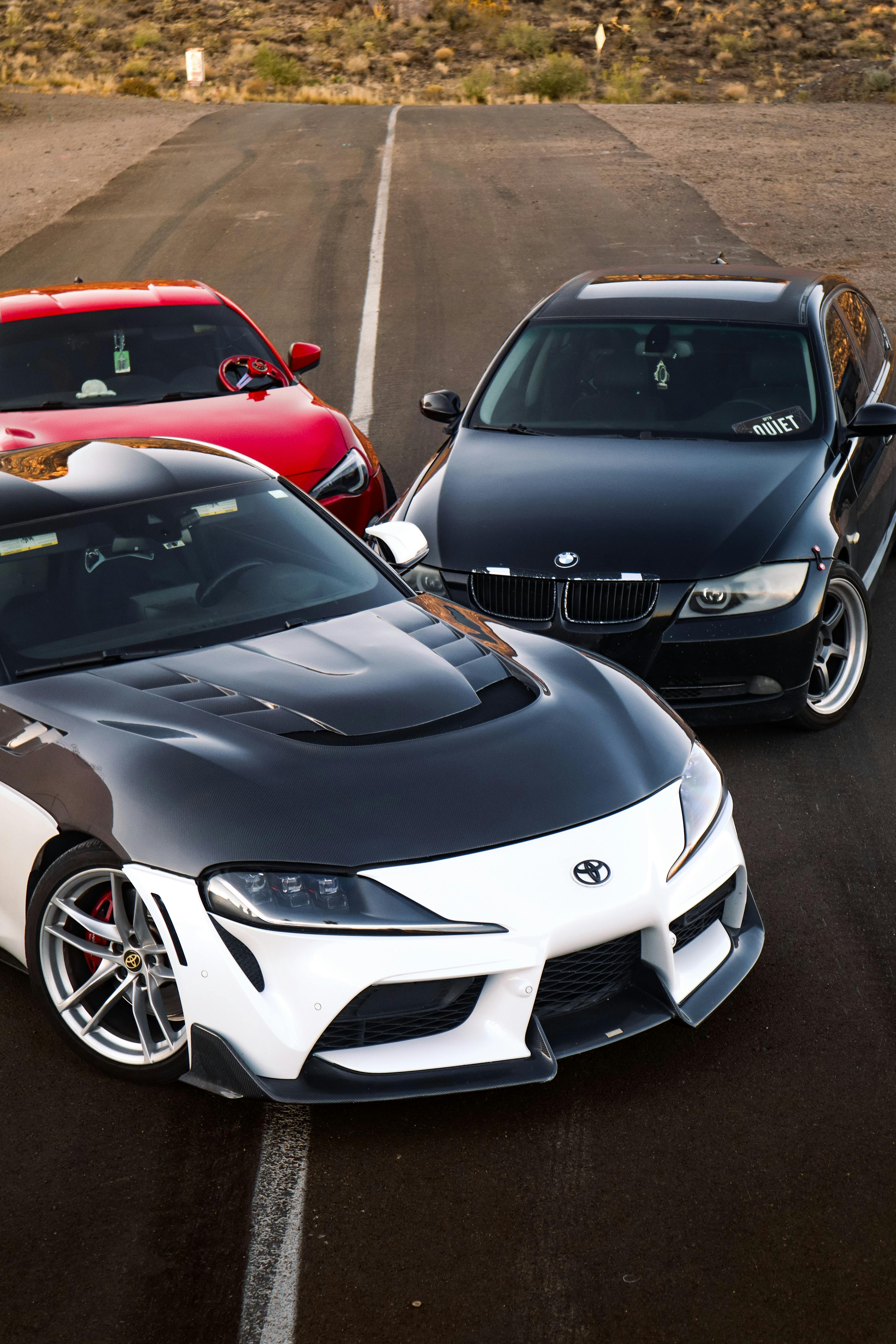 Trio of High-Performance Sports Cars on Open Road · Free Stock Photo