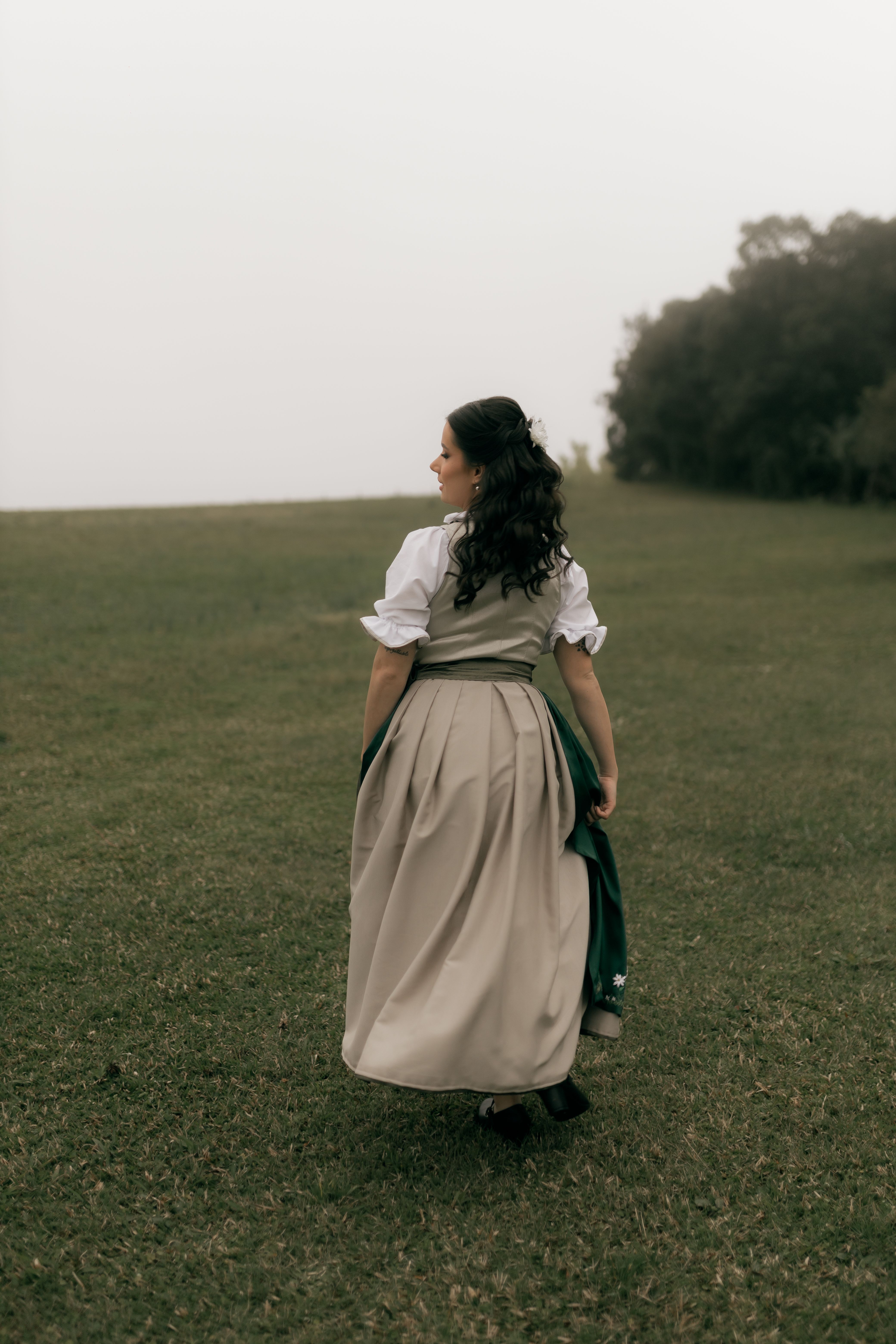 Woman in Traditional Dress Walking on Scenic Field · Free Stock Photo