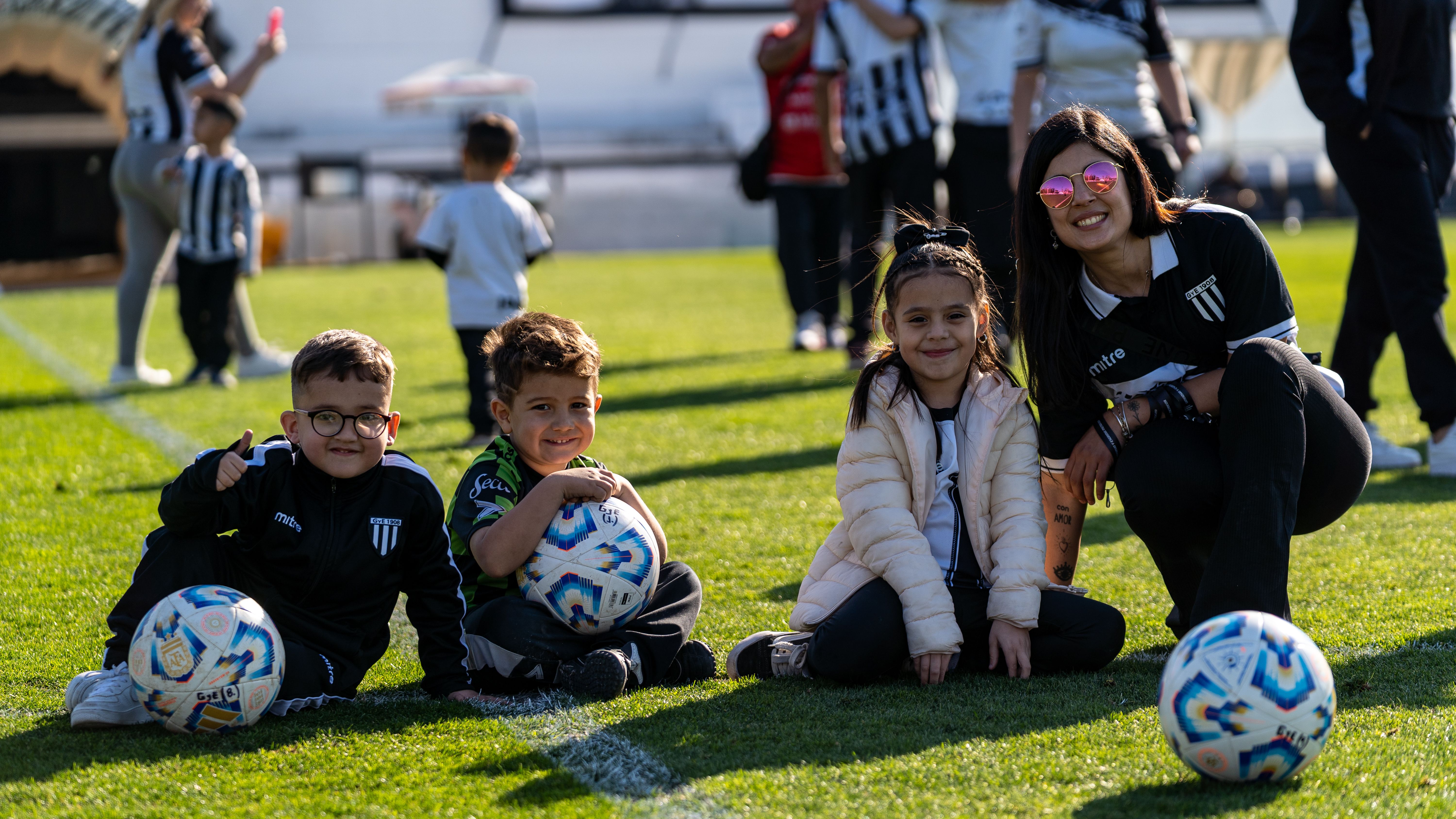 Happy Kids and Coach on a Sunny Football Field · Free Stock Photo