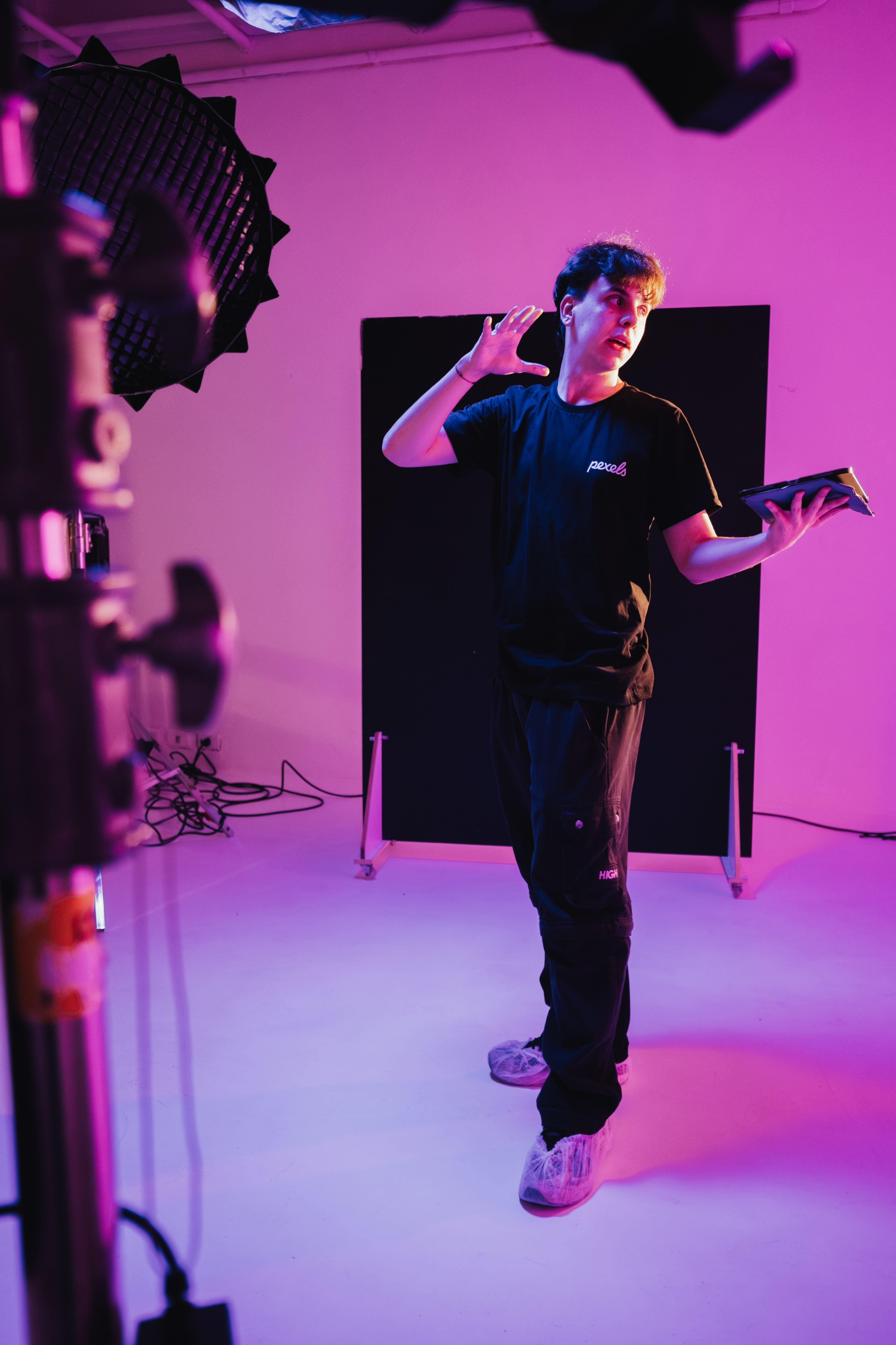 Free A young adult poses creatively in a studio with vibrant purple ...