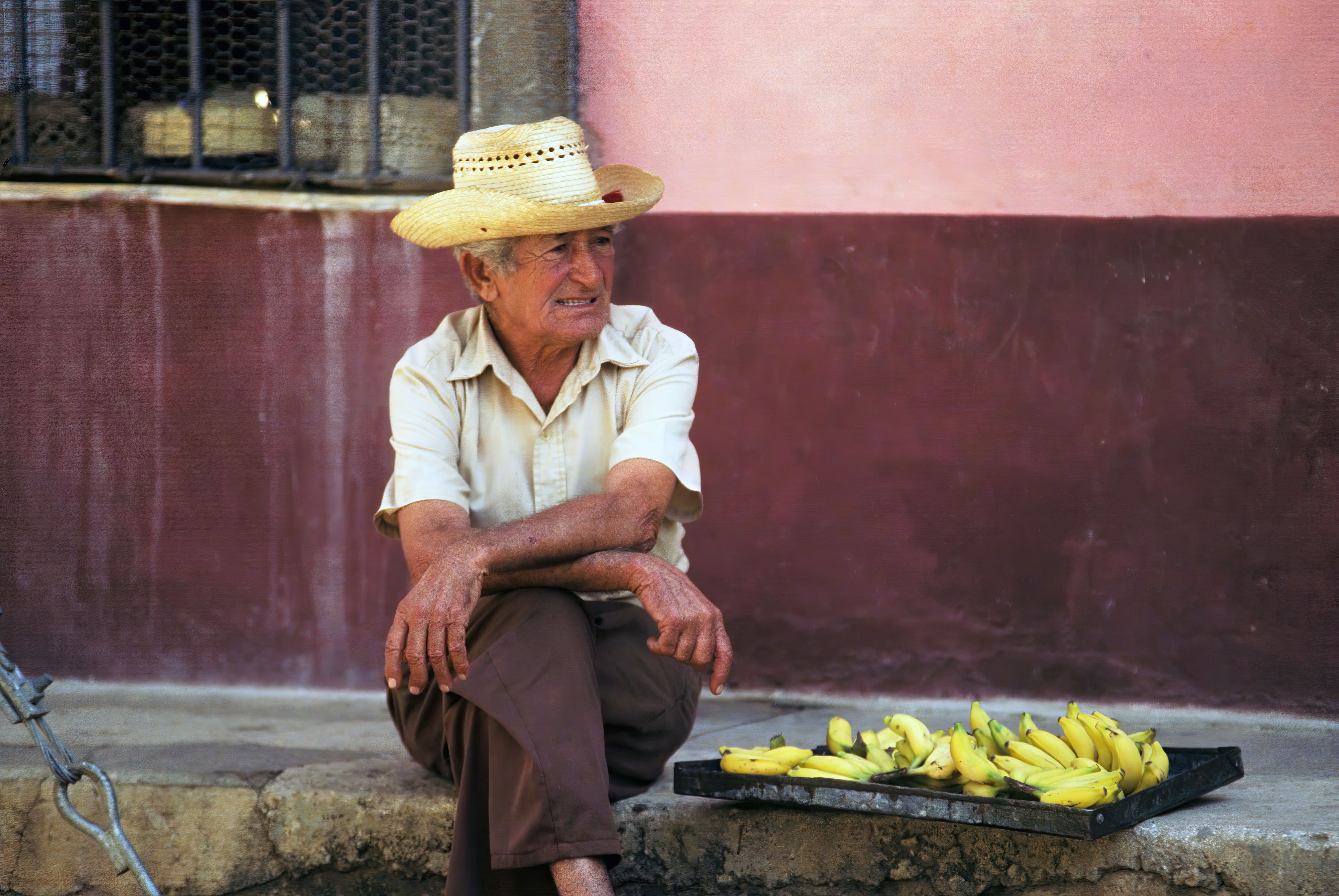 Elderly Cuban Man Selling Bananas on Sidewalk · Free Stock Photo