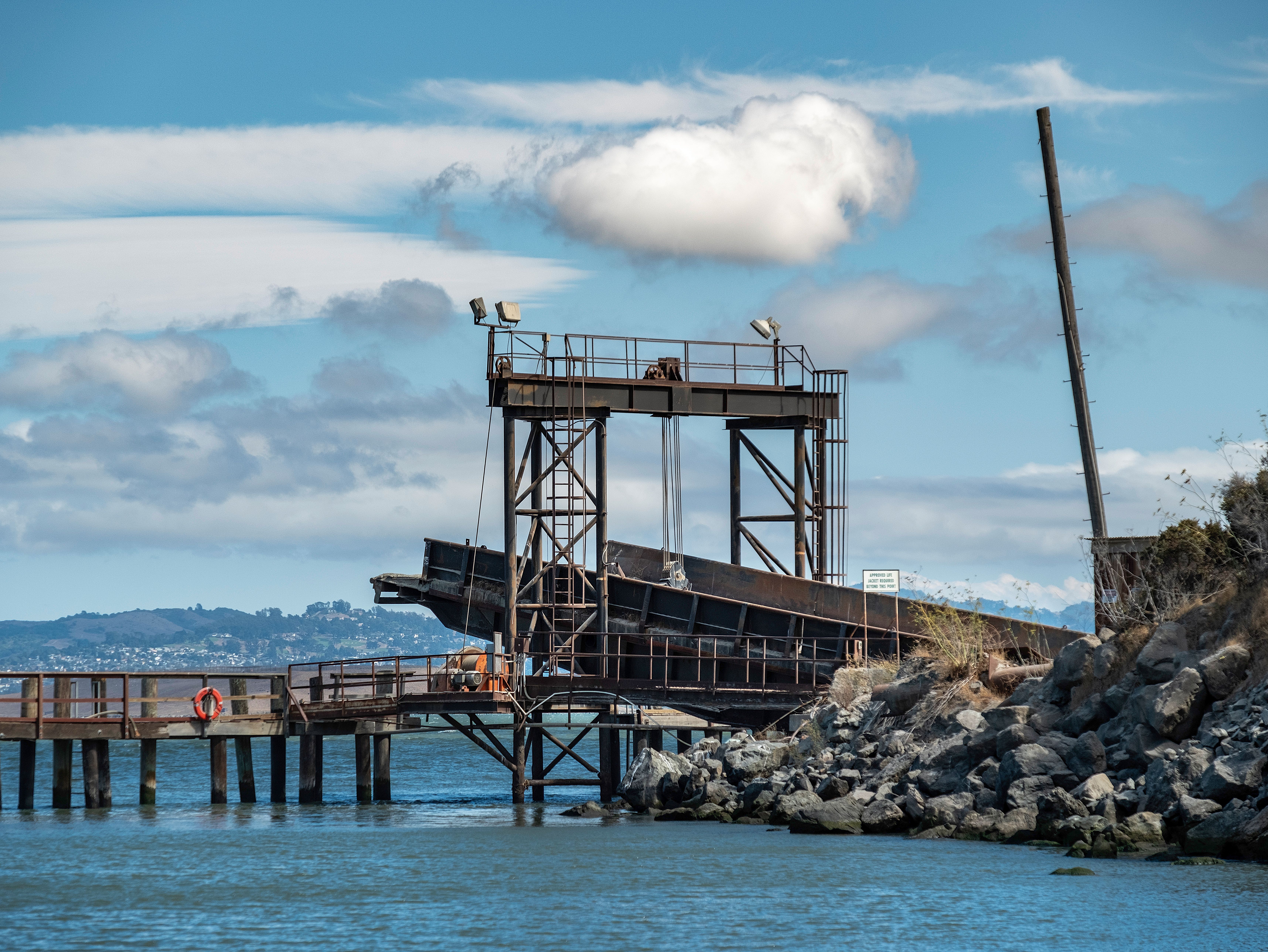 Rustic Waterfront Structure on Rocky Shoreline · Free Stock Photo