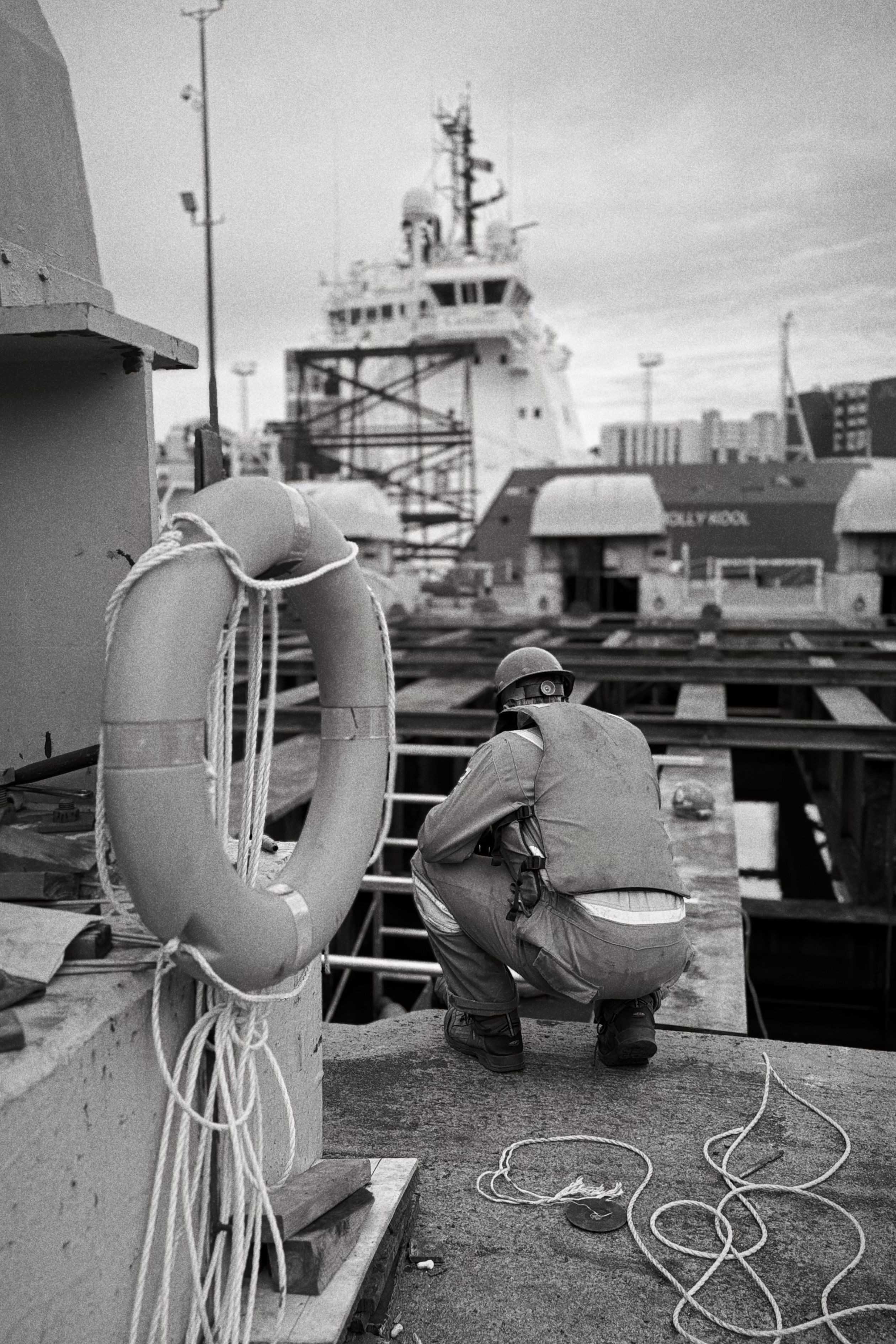 Dock Worker Inspecting Ship at Industrial Dock · Free Stock Photo
