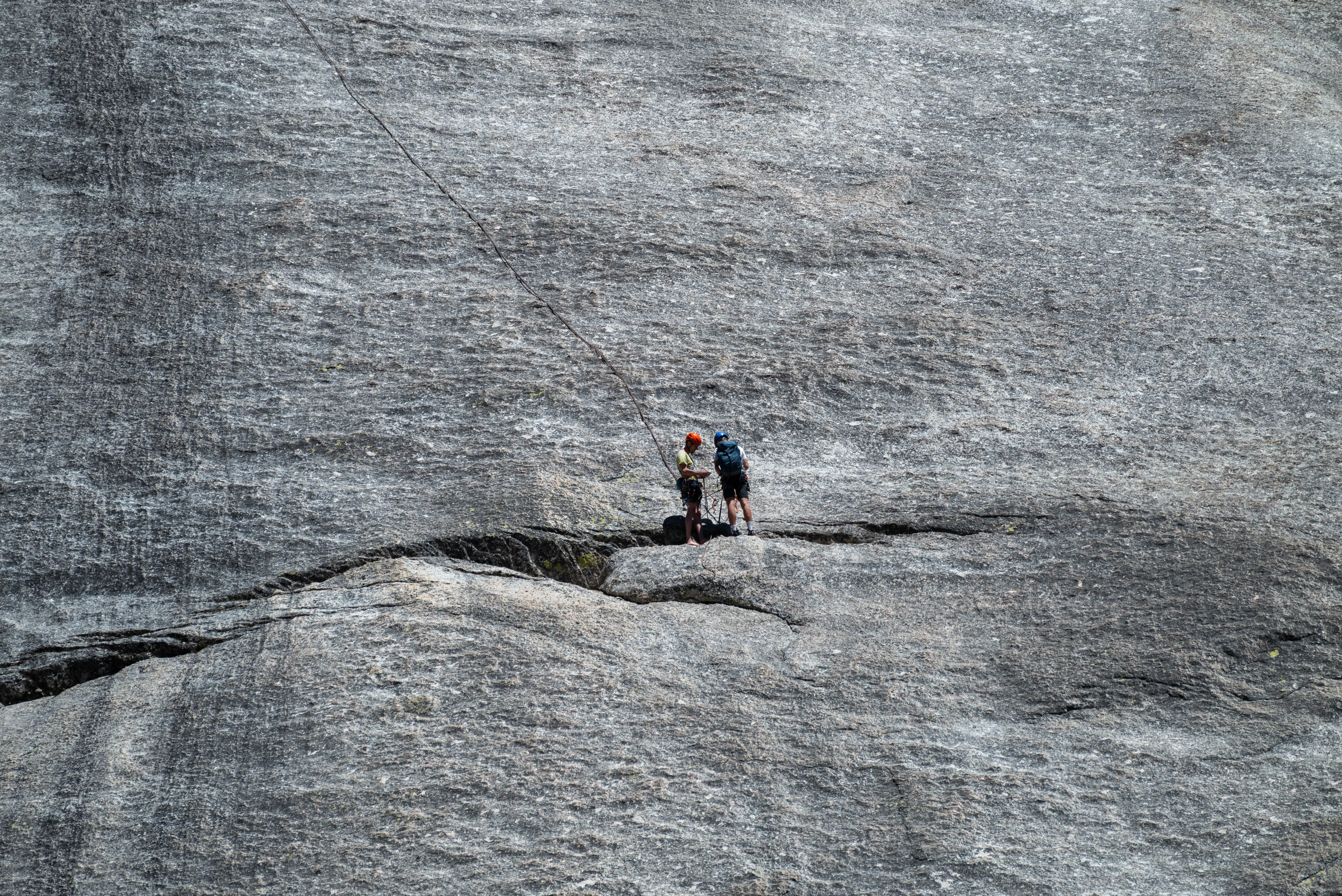 Climbers Ascending a Rugged Rock Surface · Free Stock Photo