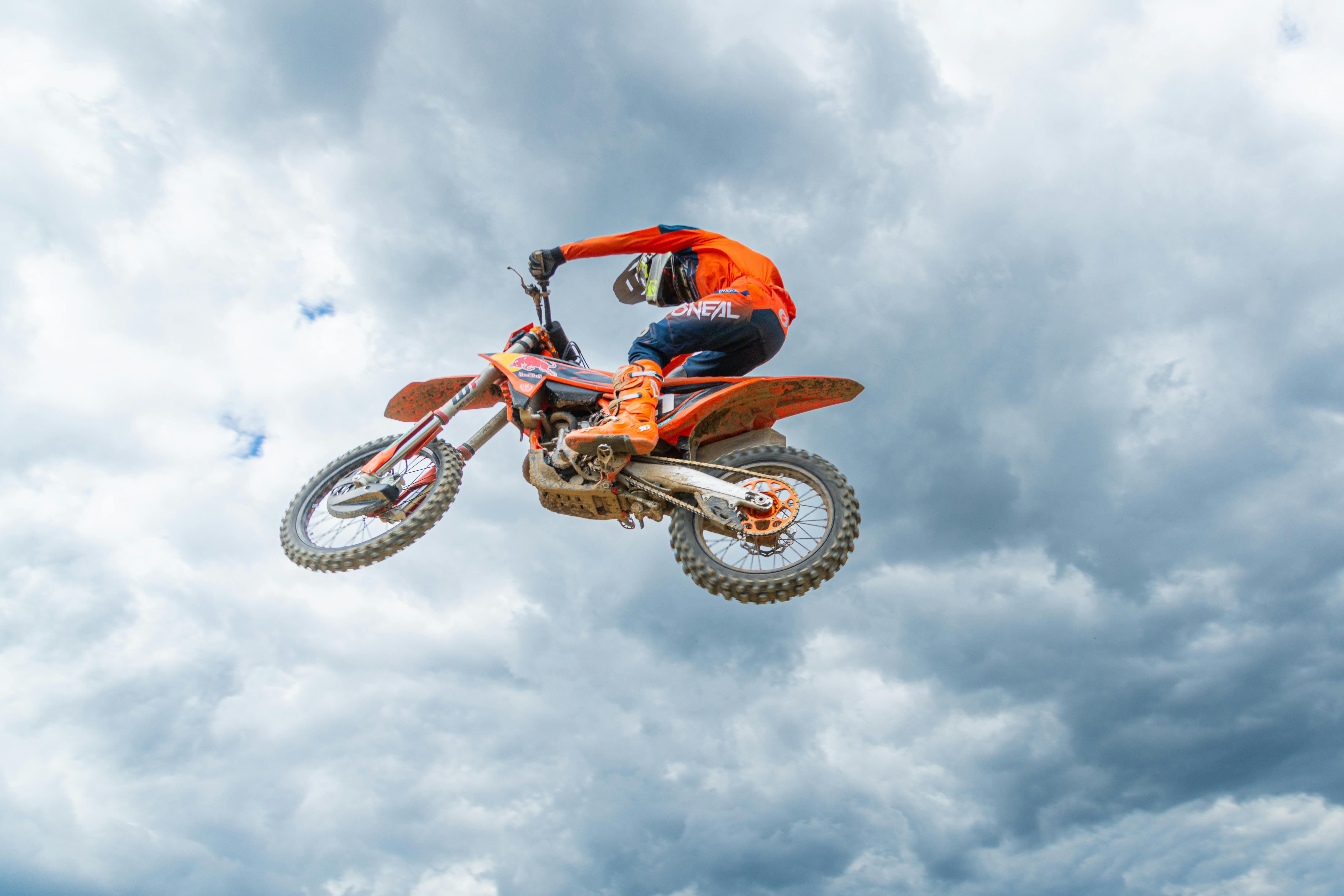 Dramatic Dirt Bike Jump Against Cloudy Sky · Free Stock Photo