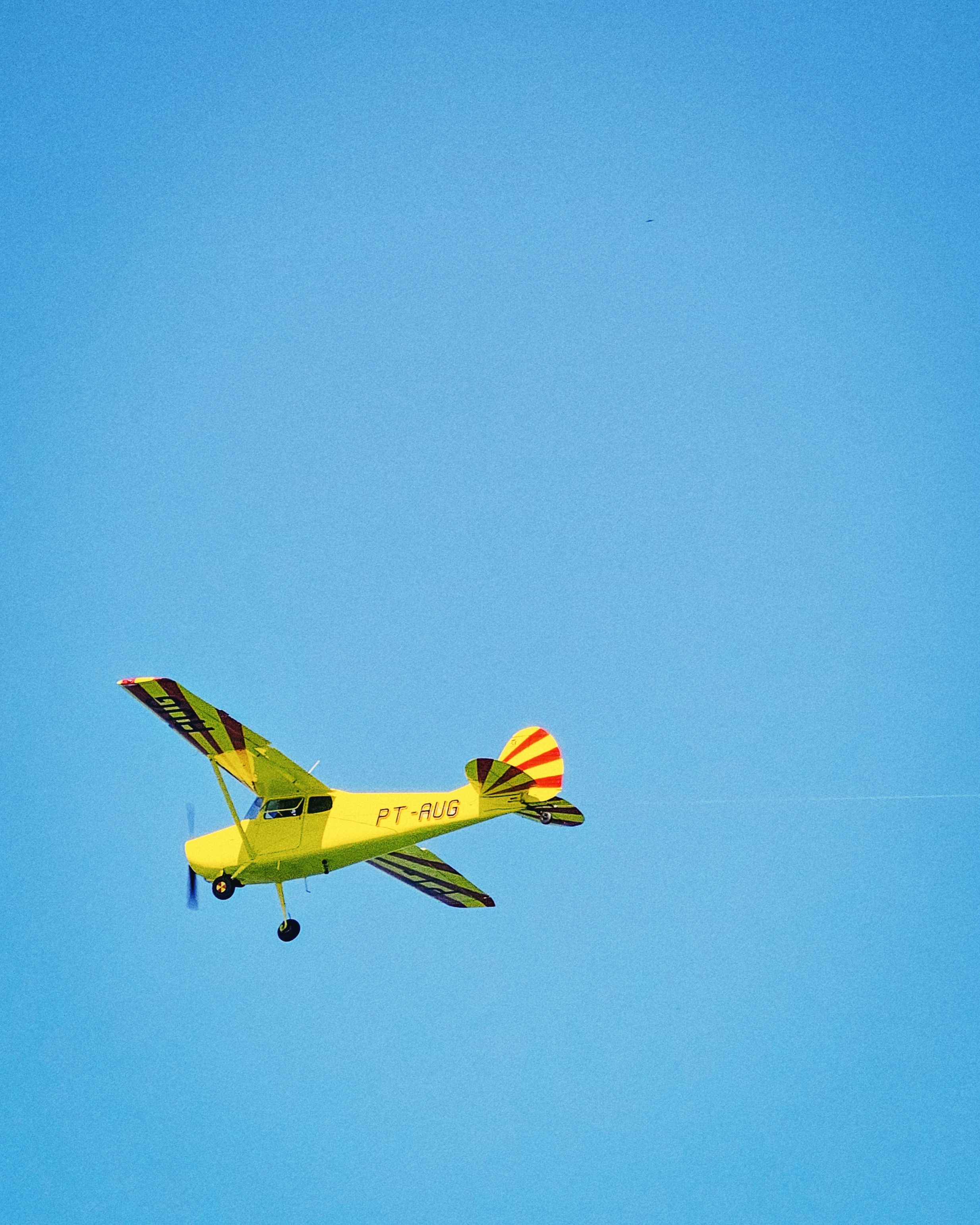 Bright Yellow Small Aircraft Flying in Clear Blue Sky · Free Stock Photo