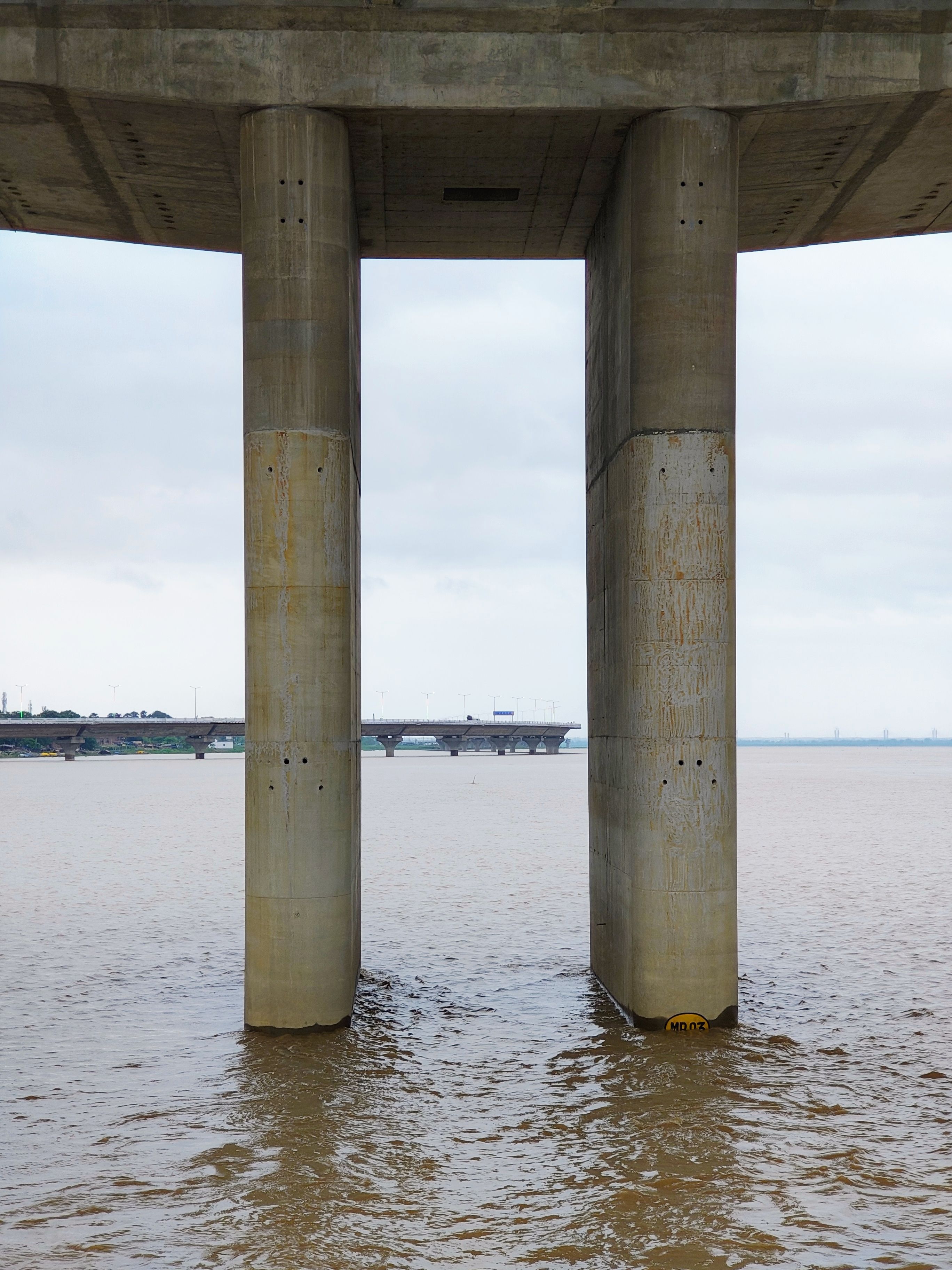 Concrete Bridge Pillars Over Calm River Water · Free Stock Photo