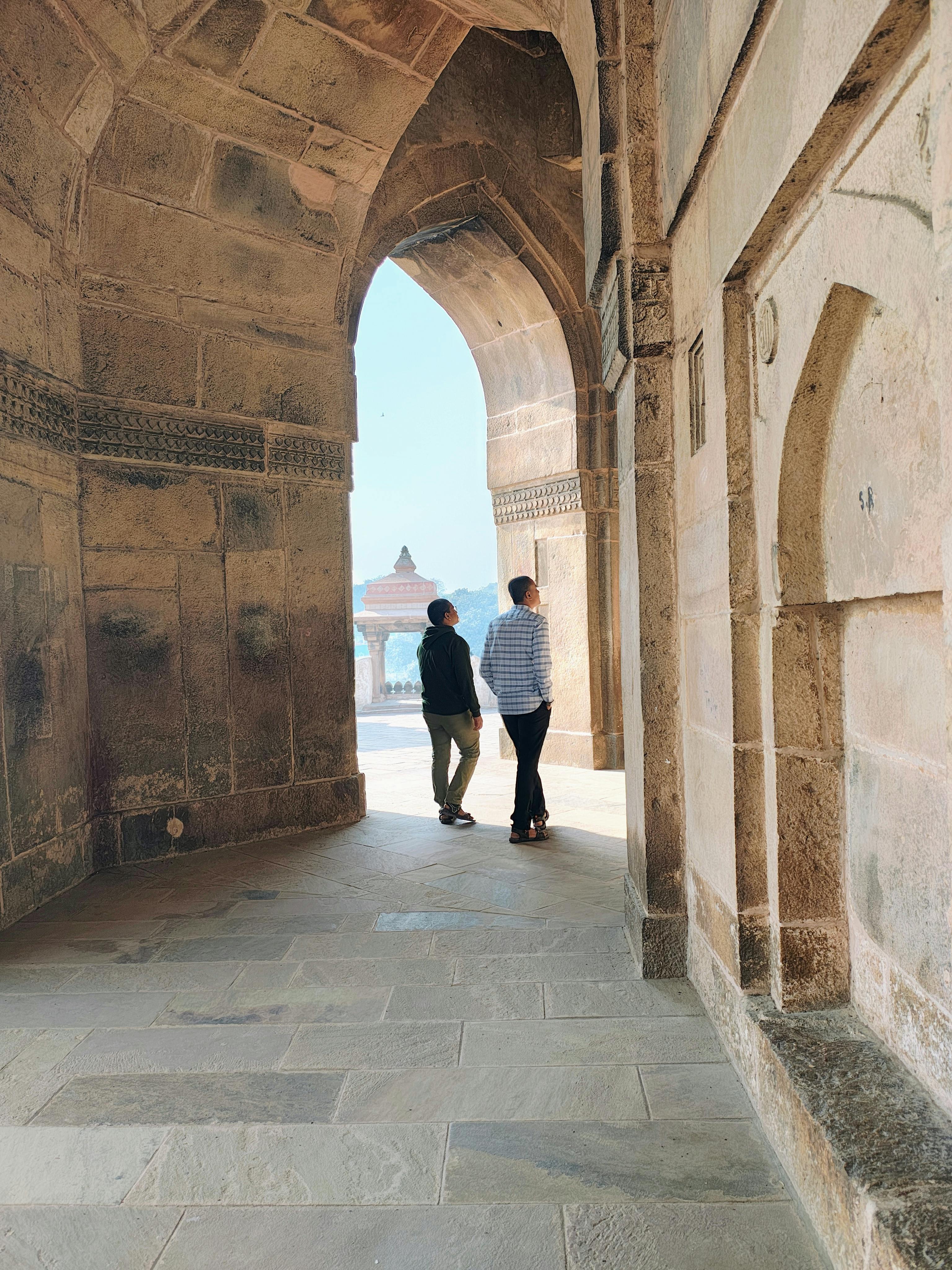 Exploring Ancient Stone Corridor with Arches · Free Stock Photo