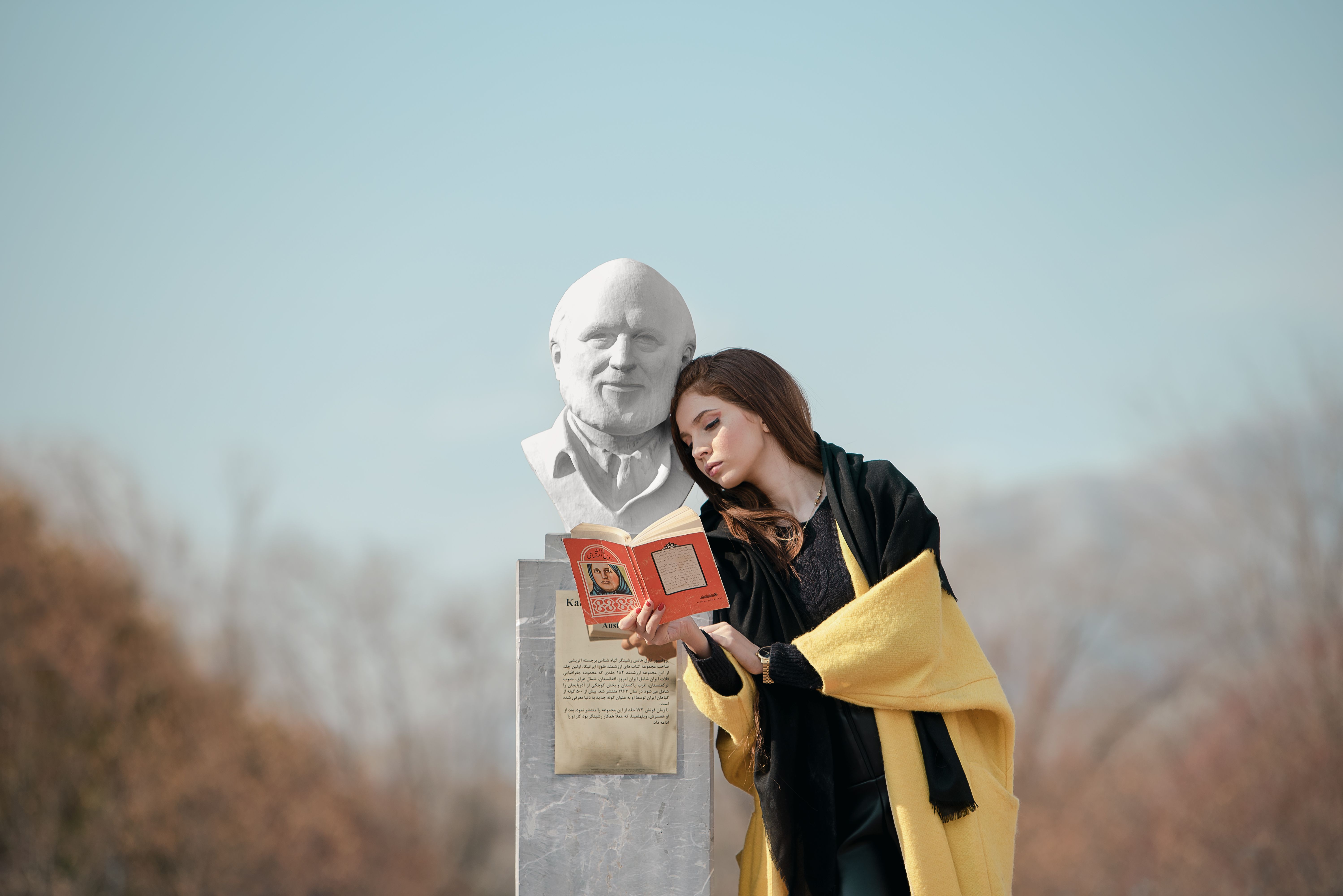 Young Woman Reading by Bust in Tehran Park · Free Stock Photo