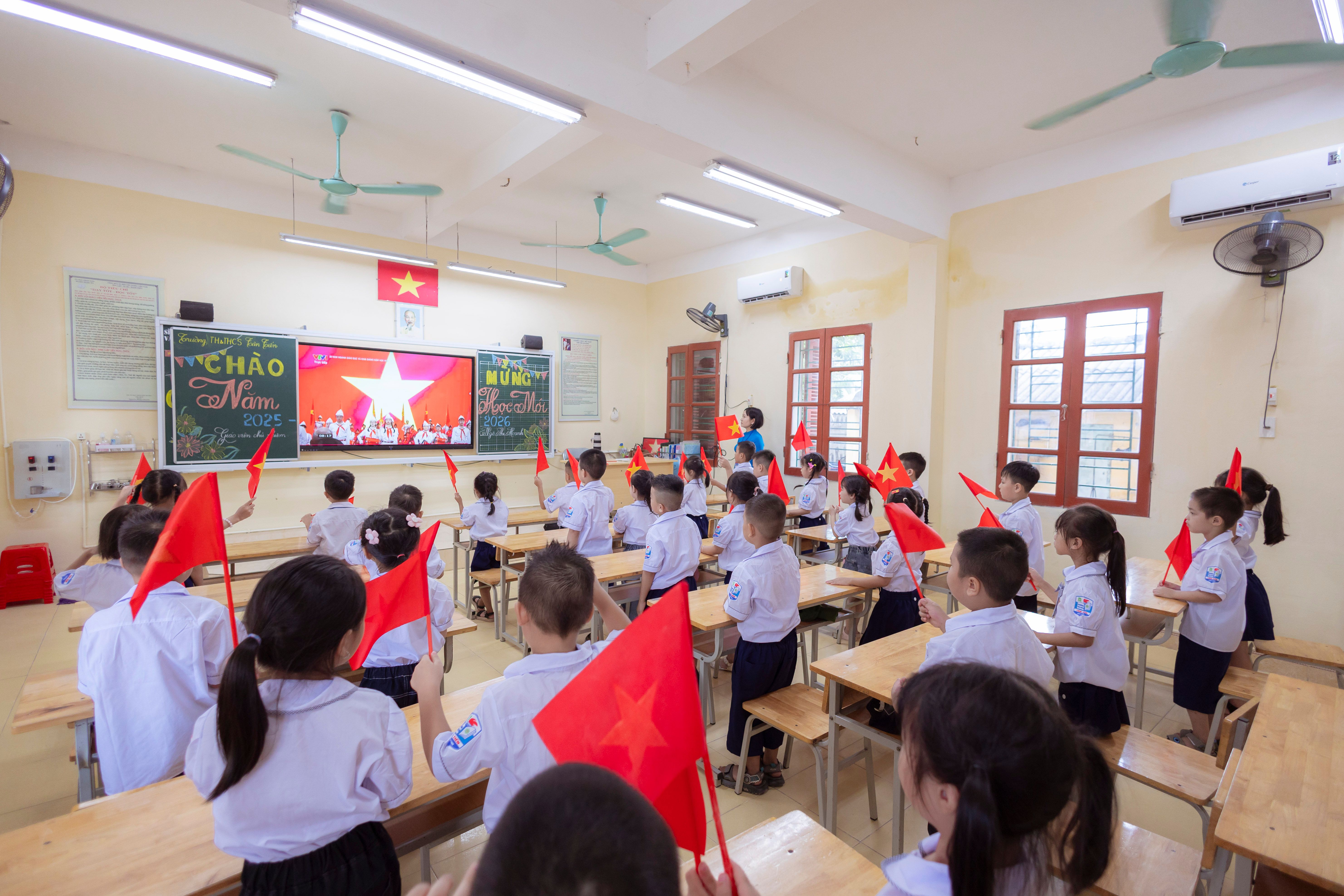 Children waving flags in classroom celebration · Free Stock Photo