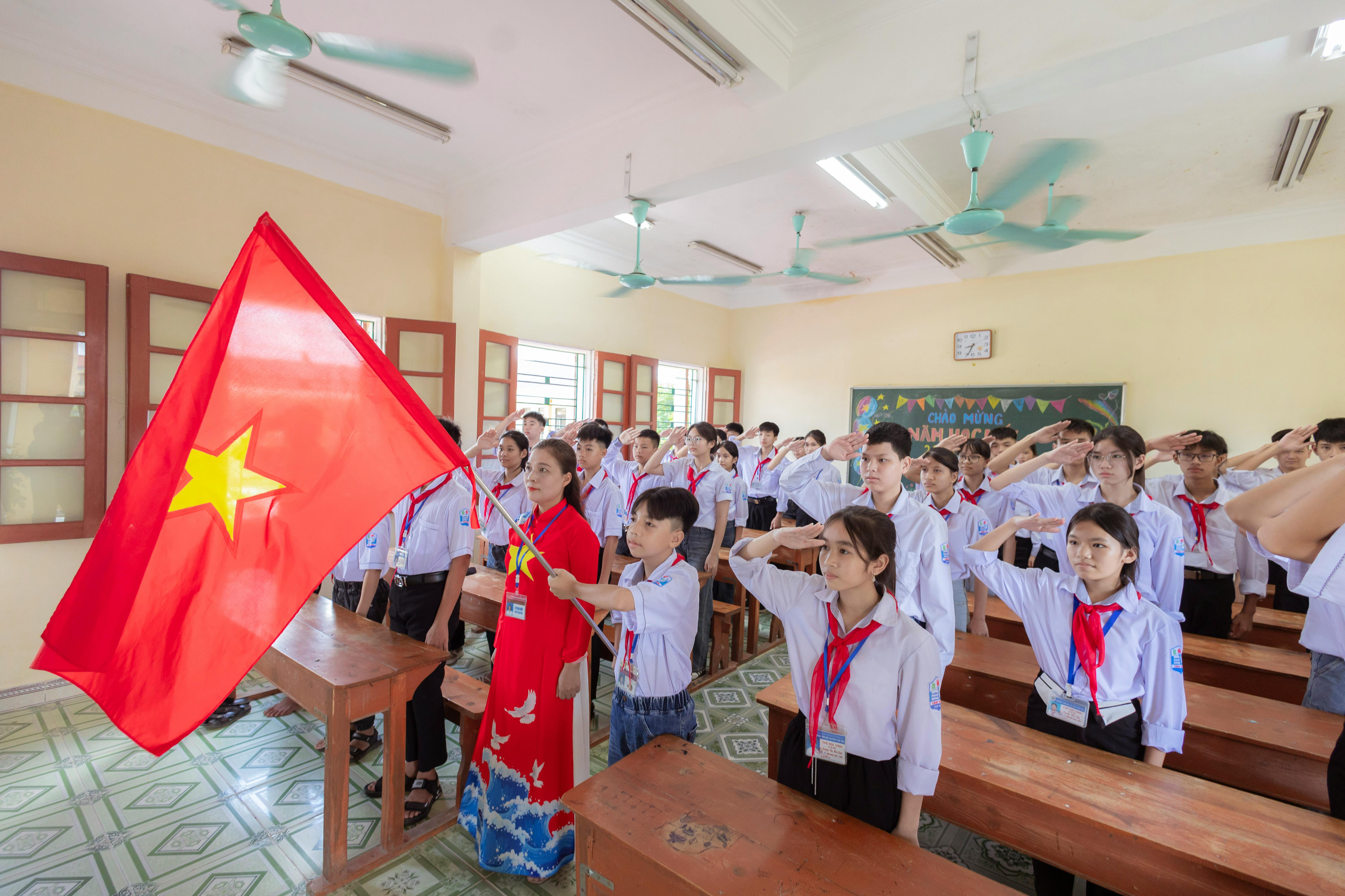 Students Saluting with National Flag Indoors · Free Stock Photo