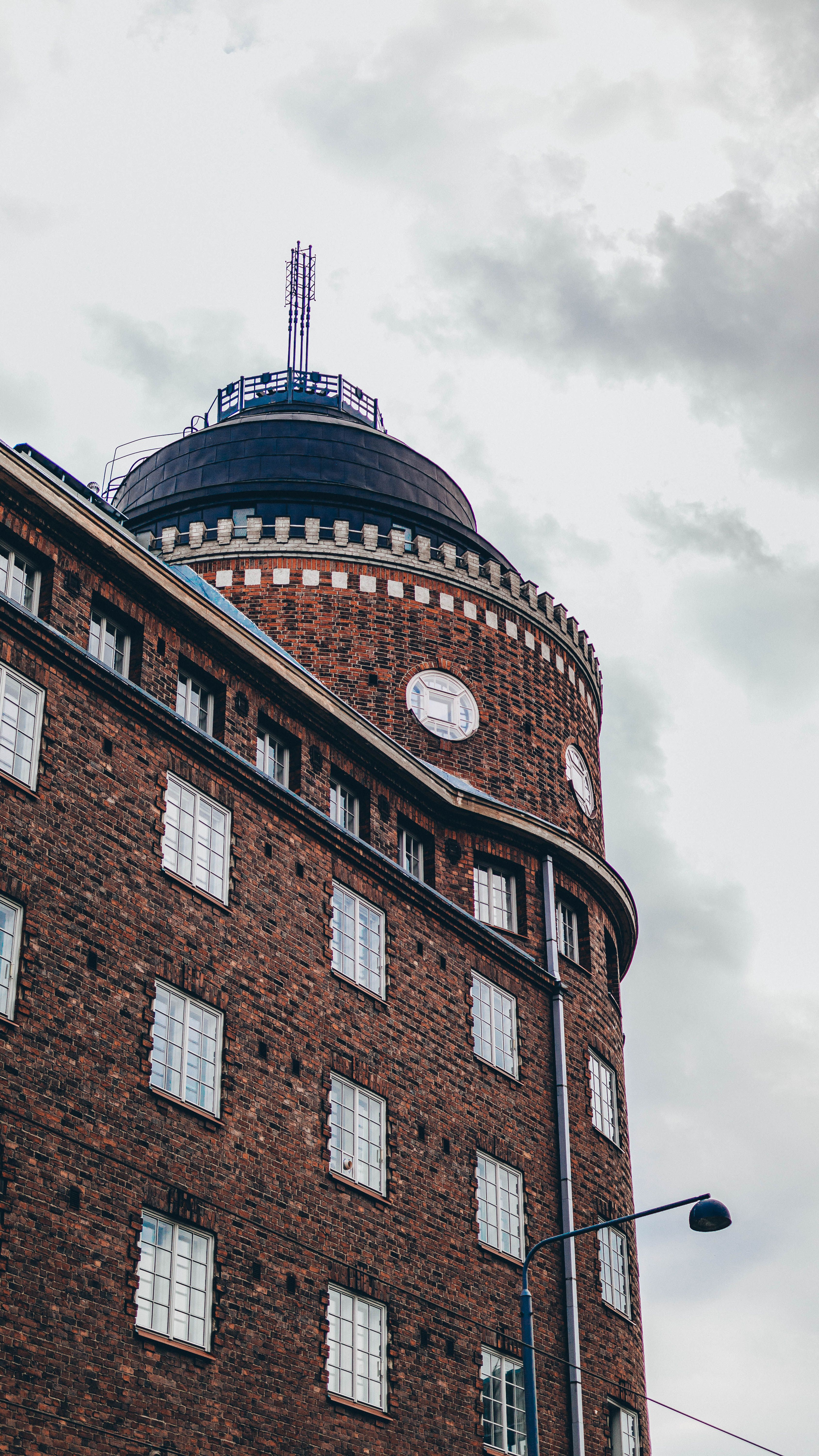 Historic Brick Tower Against Cloudy Sky · Free Stock Photo