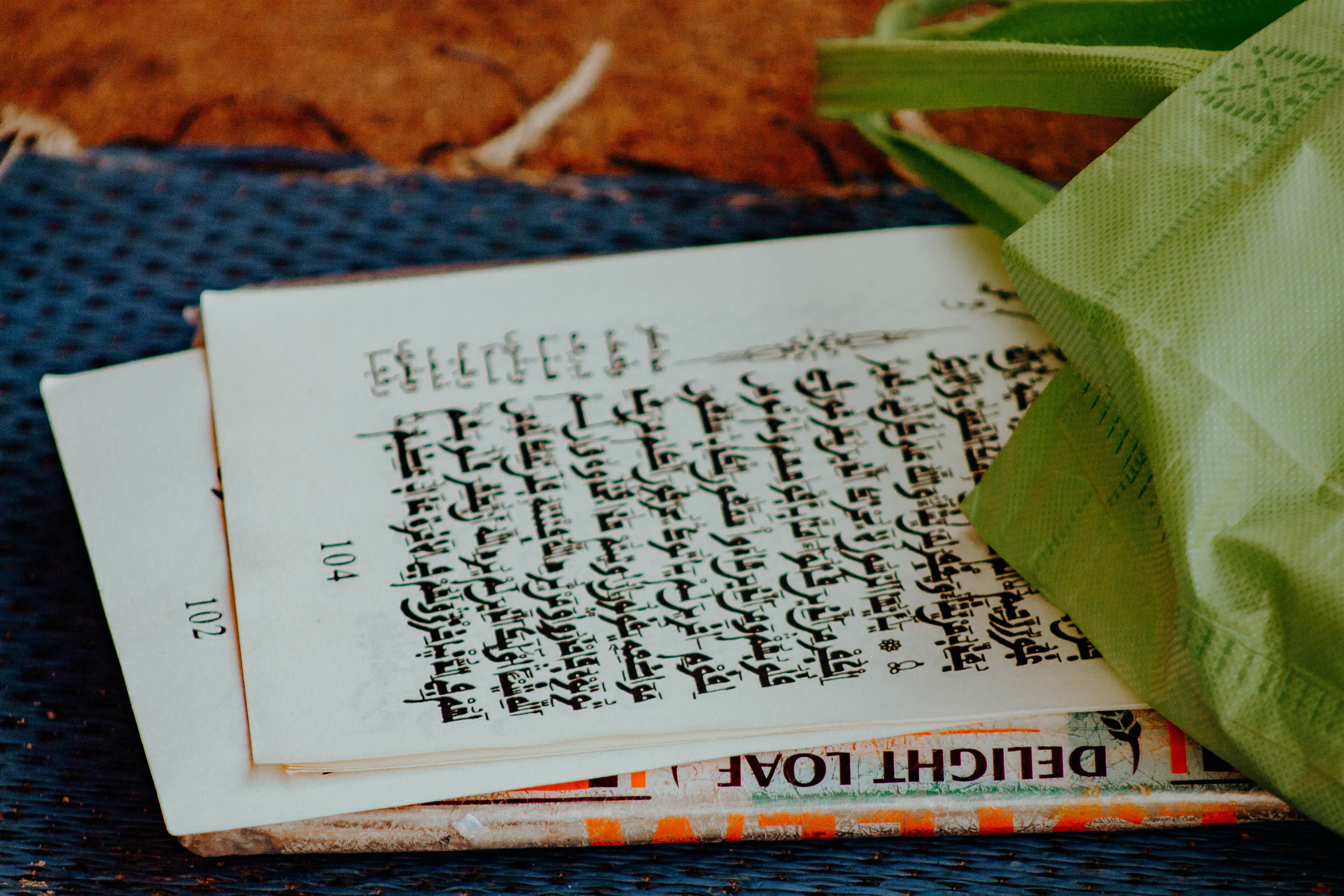Close-up of Old Manuscript and Green Bag · Free Stock Photo