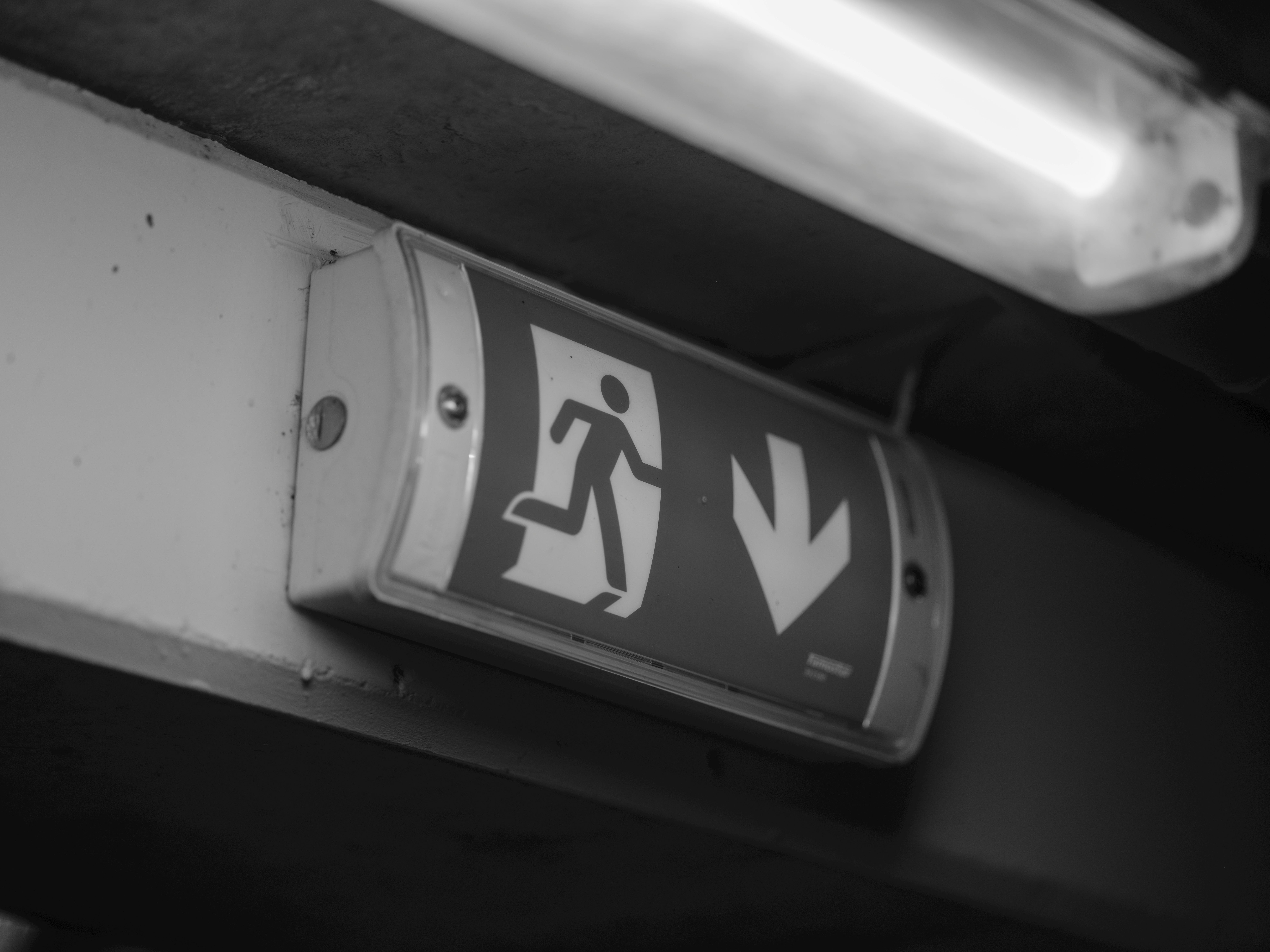 Black and White Emergency Exit Sign in a Garage · Free Stock Photo