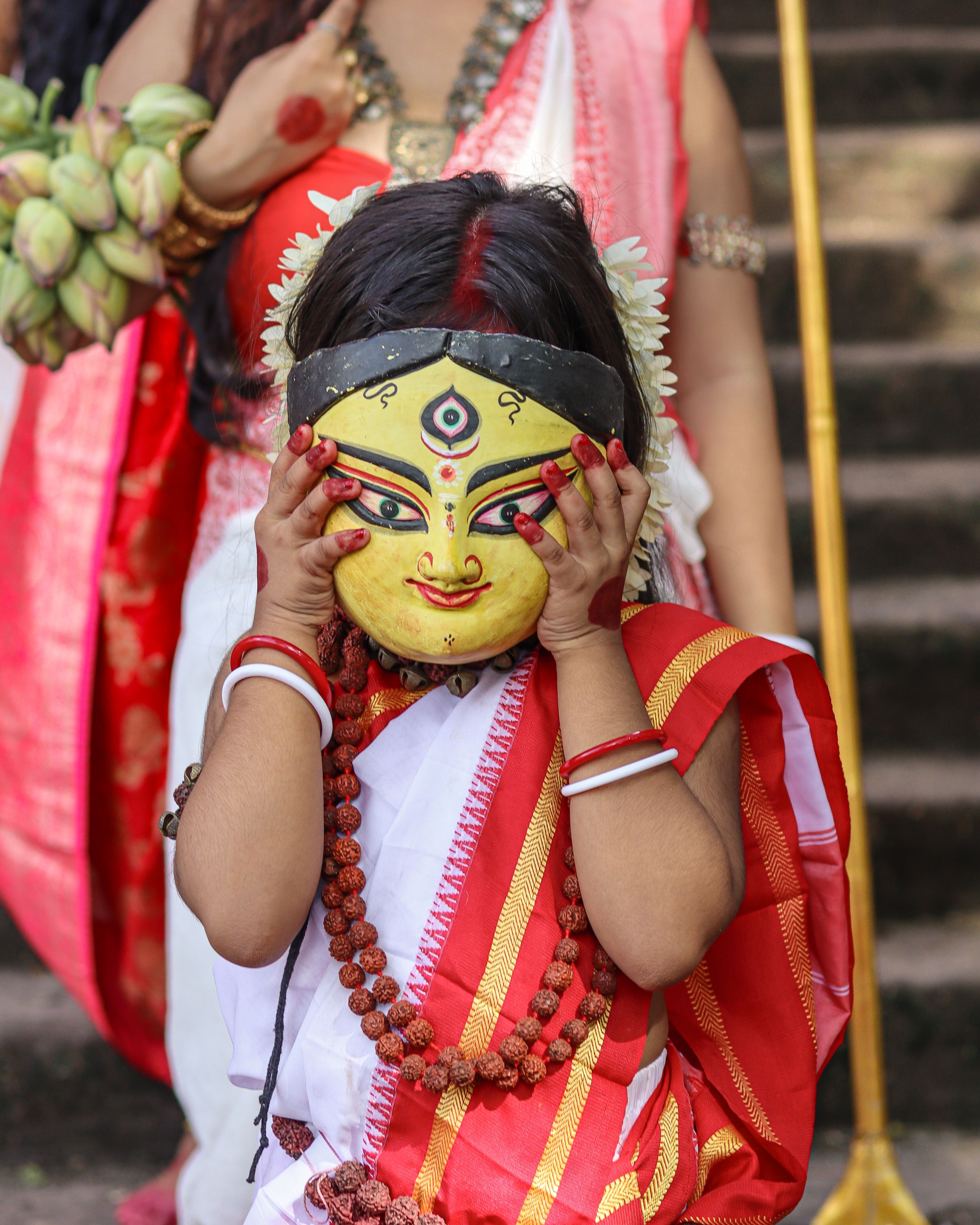 Child in Traditional Costume Holding Durga Mask · Free Stock Photo