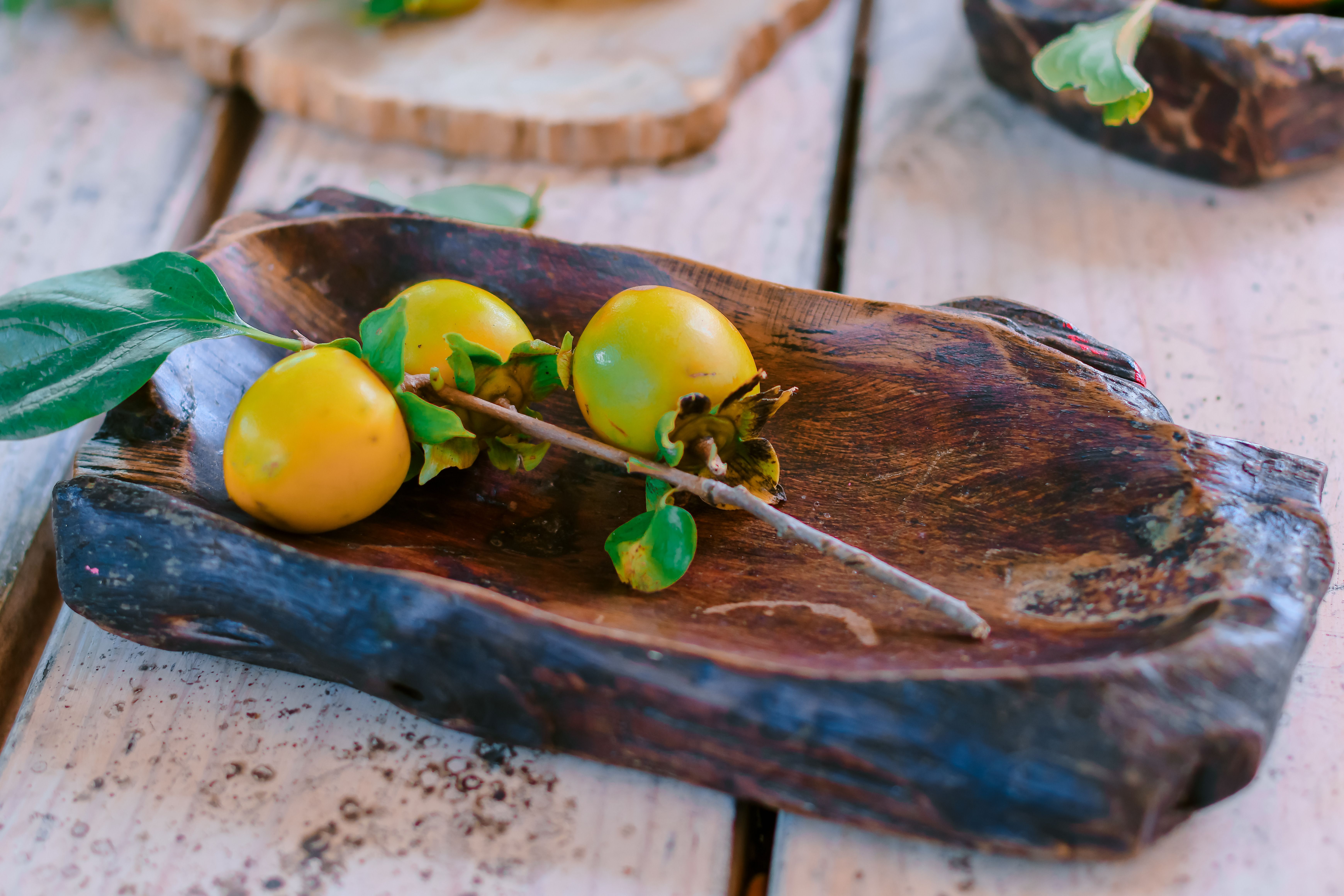 Rustic Display of Persimmons on Wooden Platter · Free Stock Photo