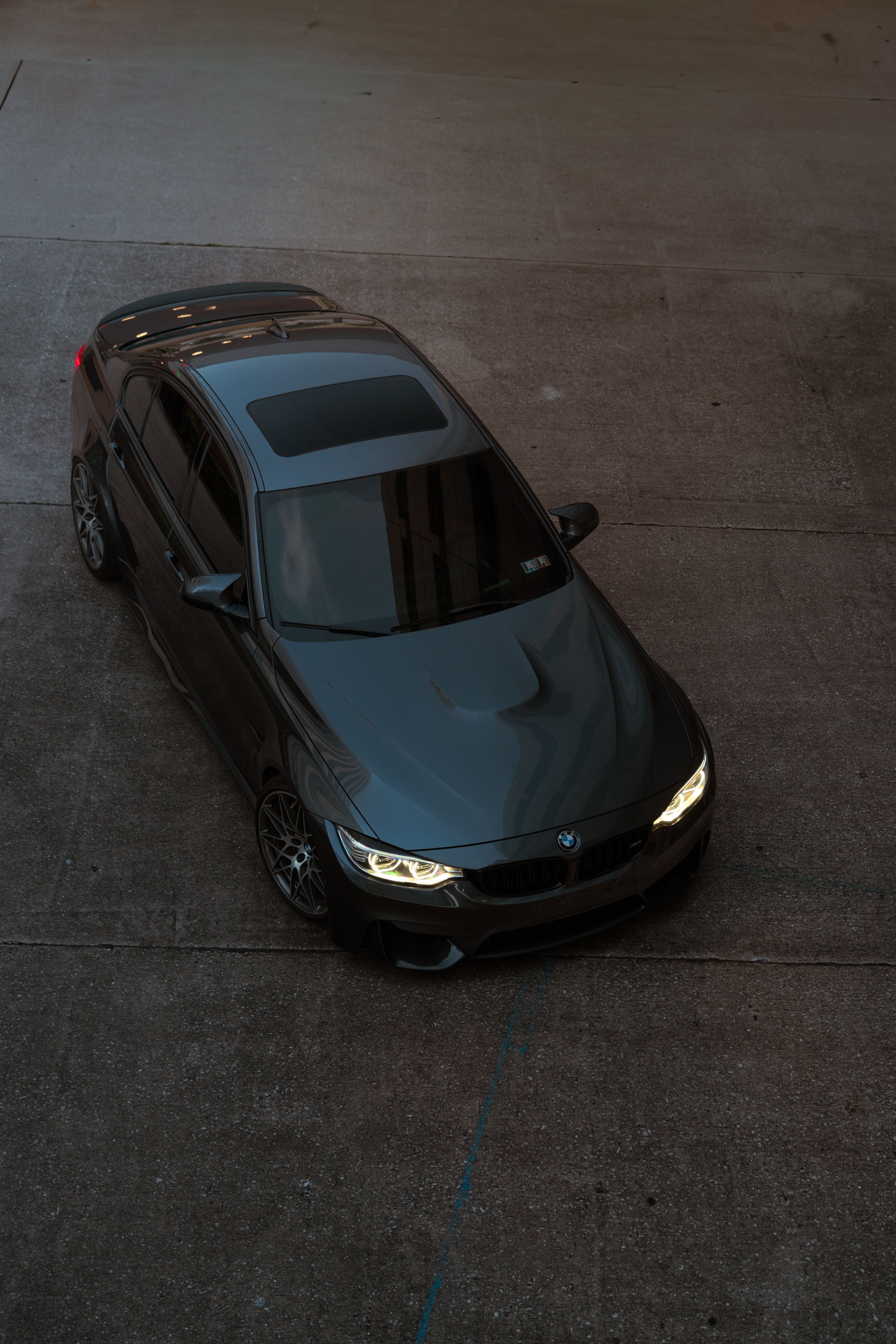 Sleek Dark Metallic Car on Urban Concrete · Free Stock Photo