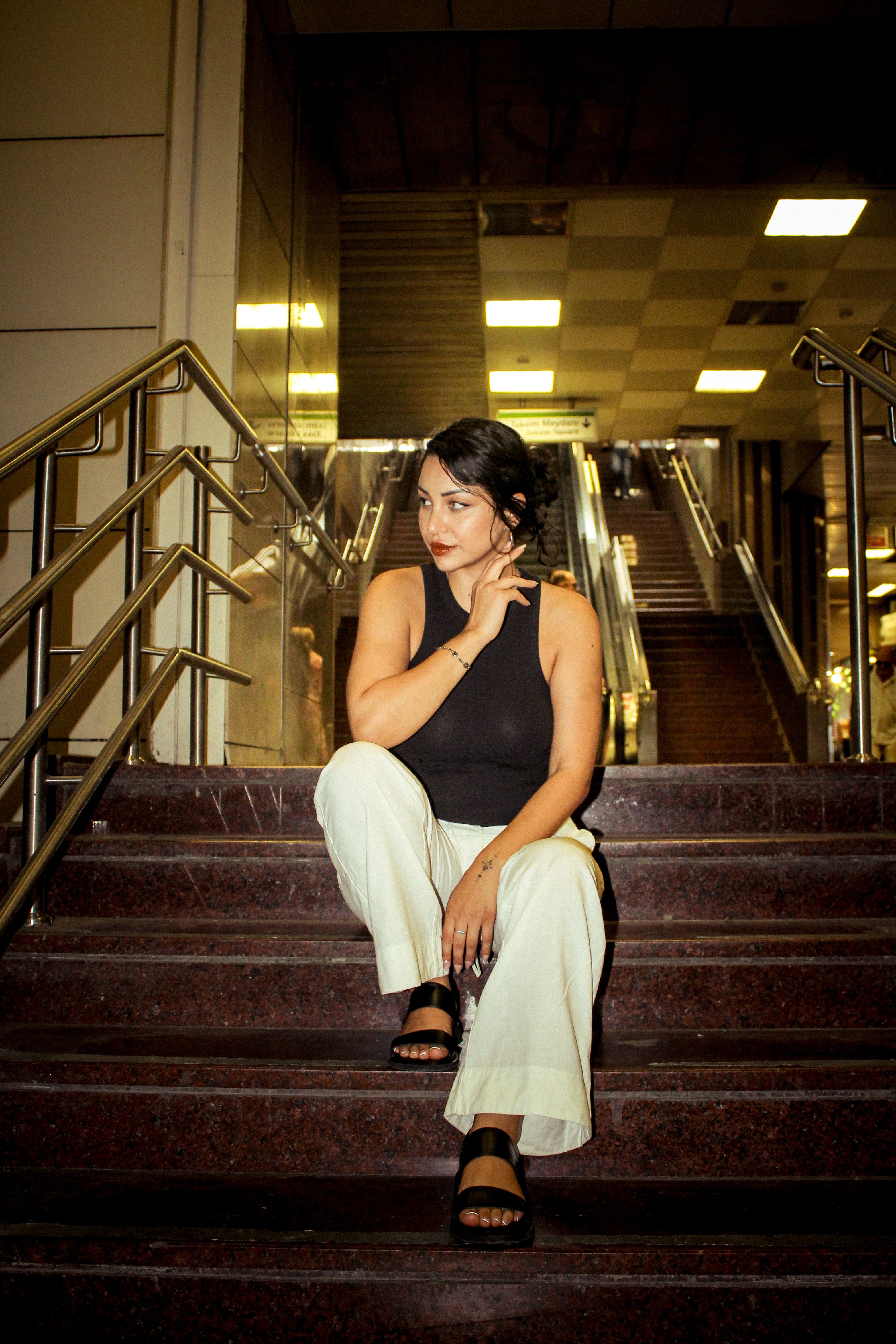 Stylish Woman Sitting on Indoor Staircase · Free Stock Photo