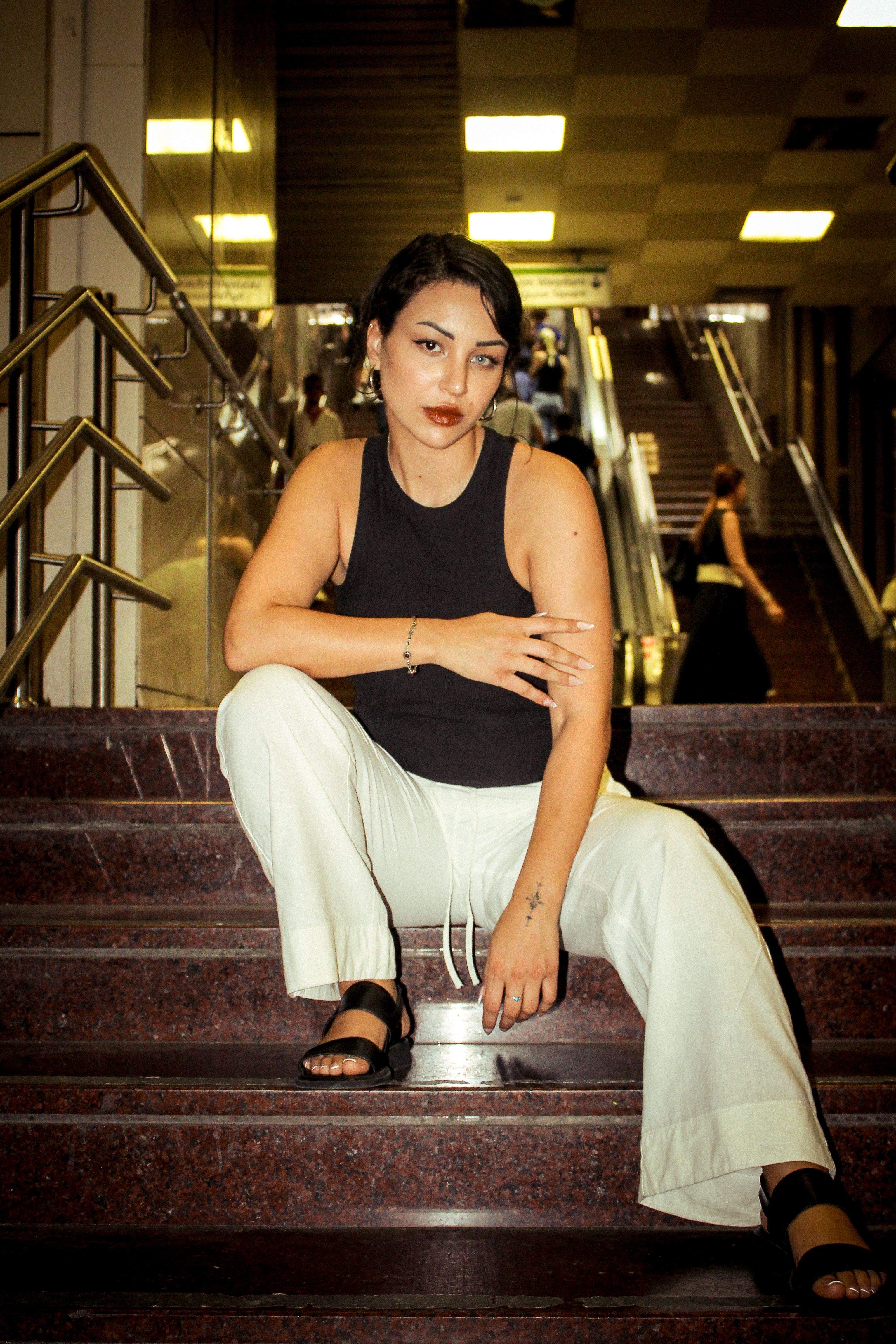 Fashionable Woman Sitting on Staircase Indoors · Free Stock Photo