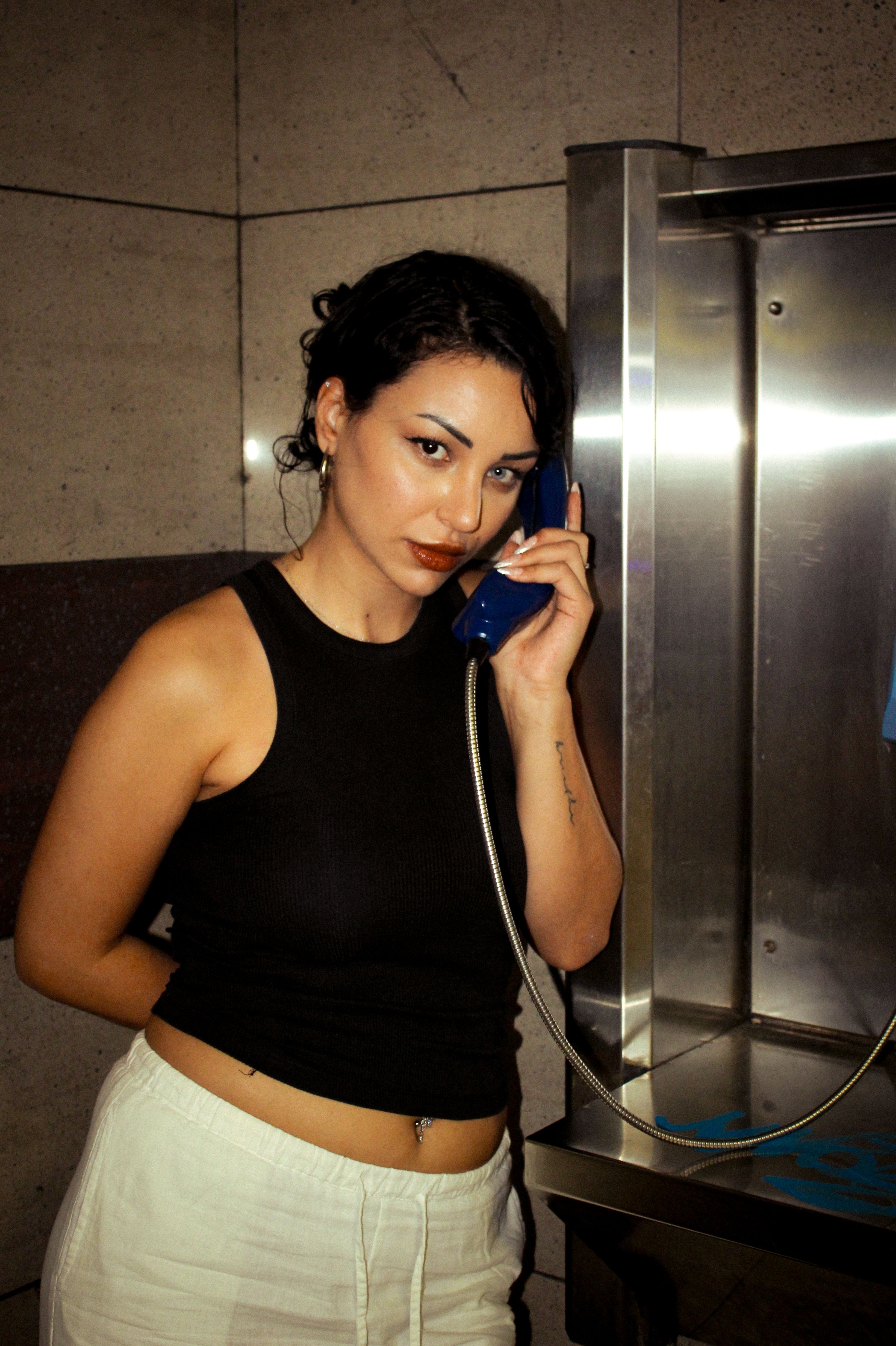 Woman using retro payphone in urban setting · Free Stock Photo
