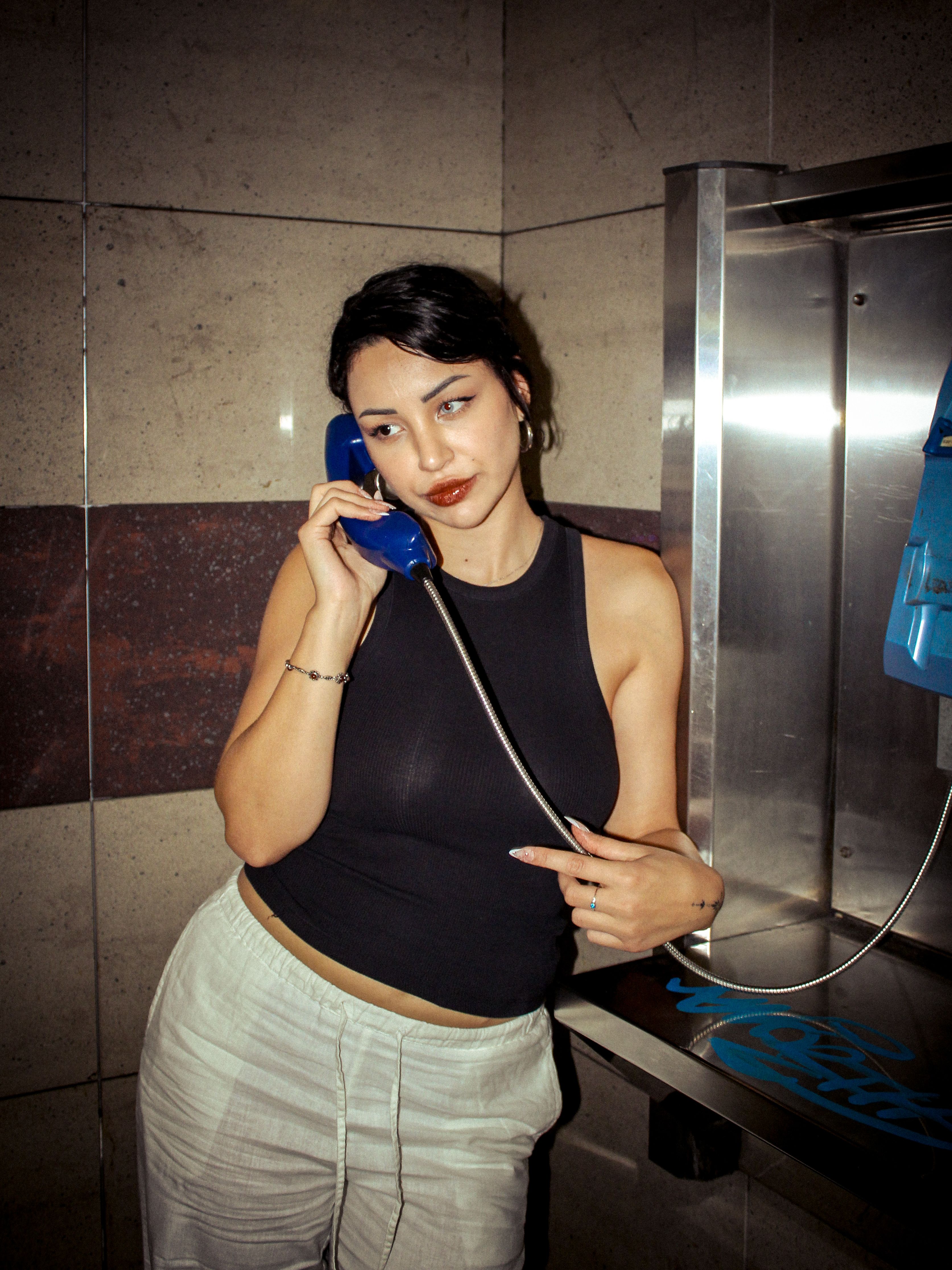 Woman Using a Vintage Payphone Indoors · Free Stock Photo