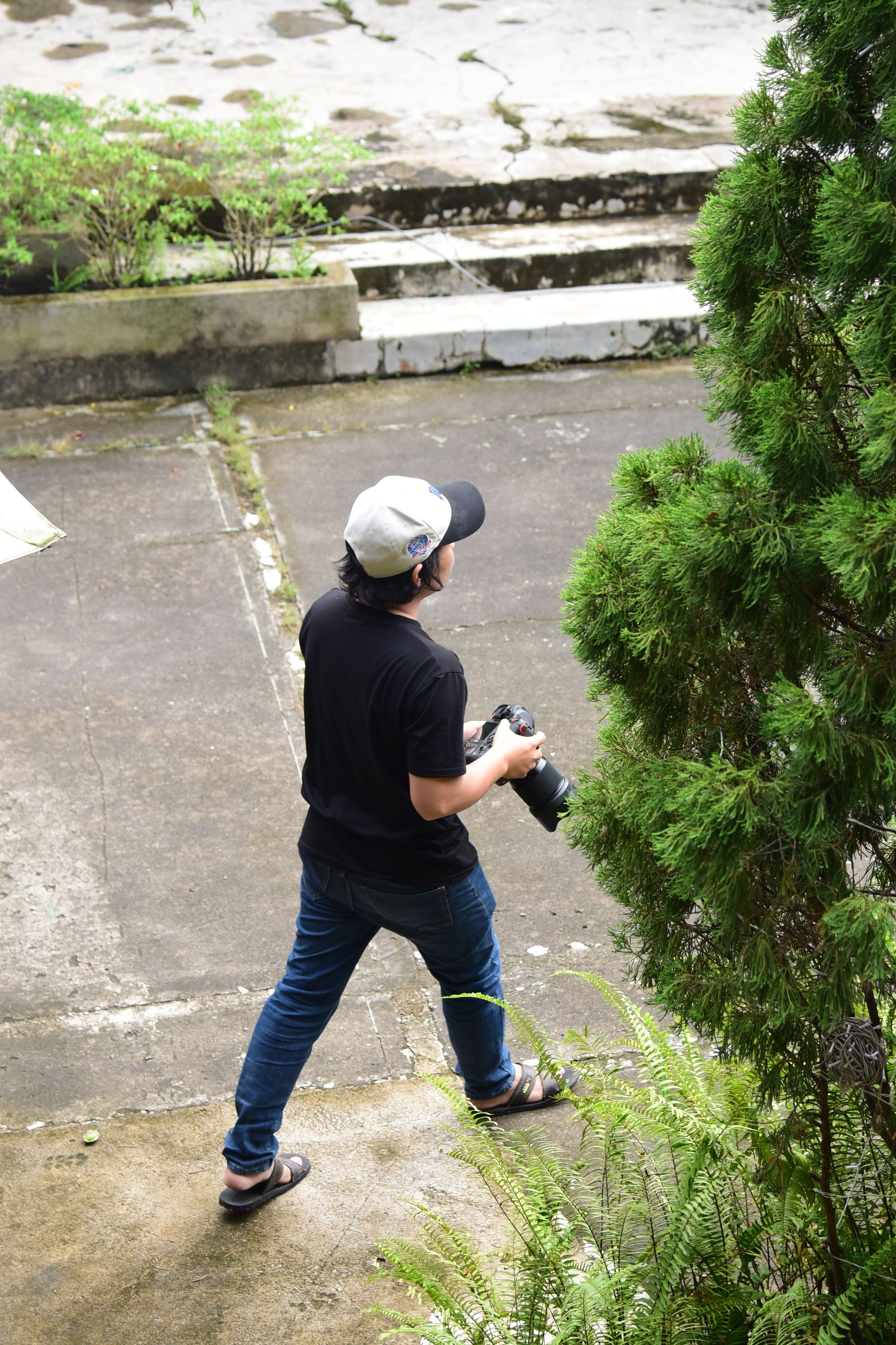 Man Walking Outdoors with Camera in Hand · Free Stock Photo