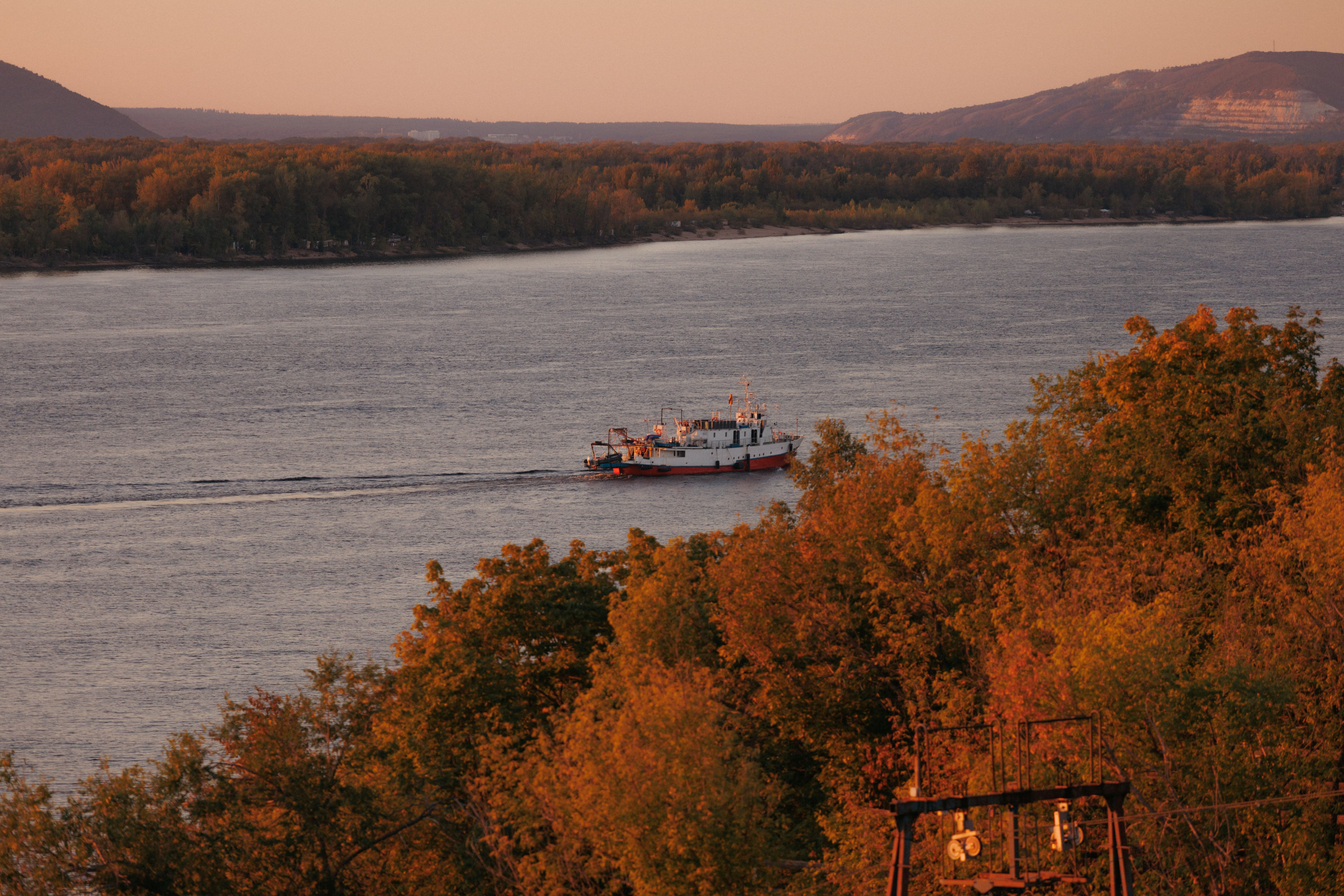 Scenic Autumn River Landscape with Boat at Sunset · Free Stock Photo