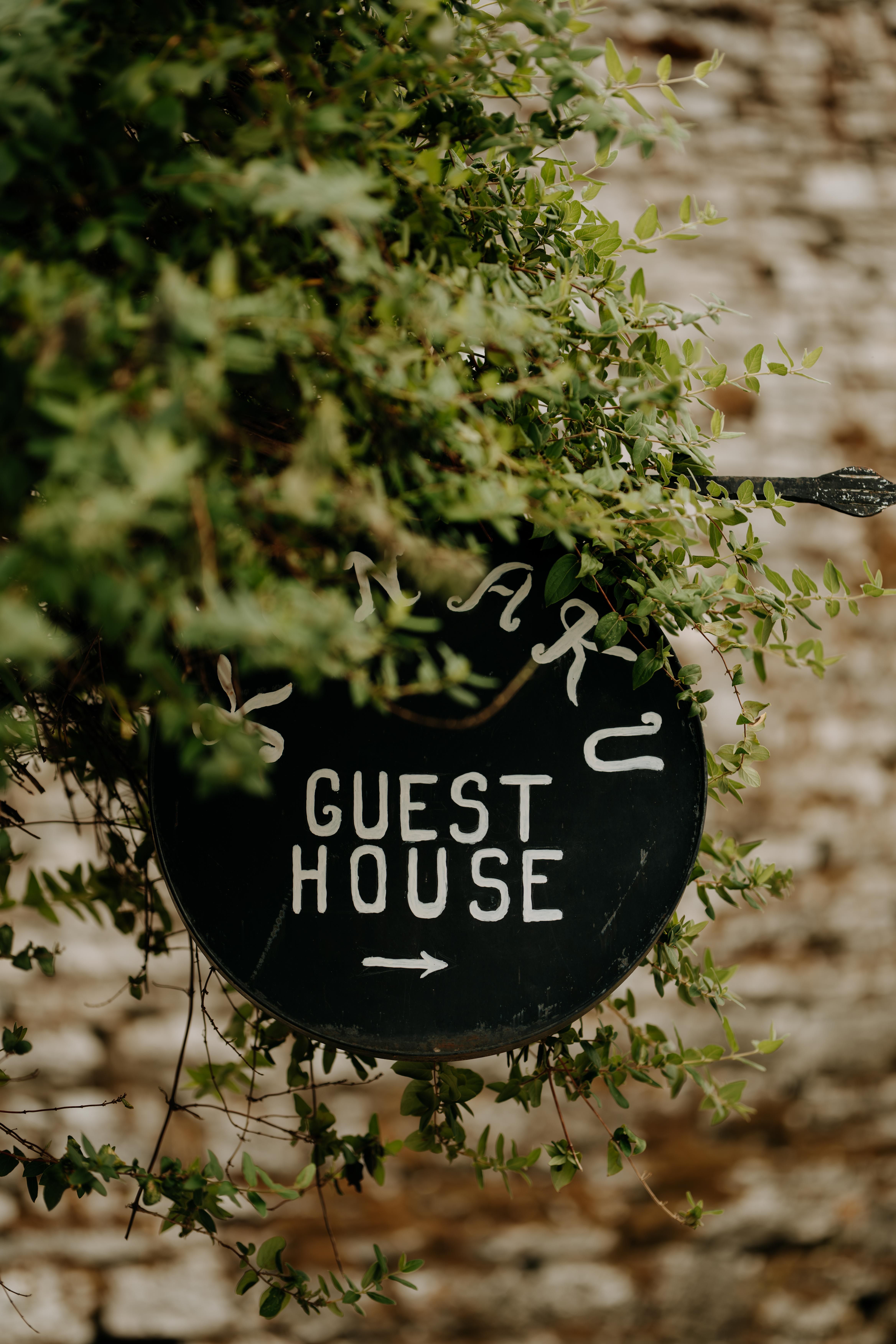 Charming Guest House Sign with Greenery · Free Stock Photo