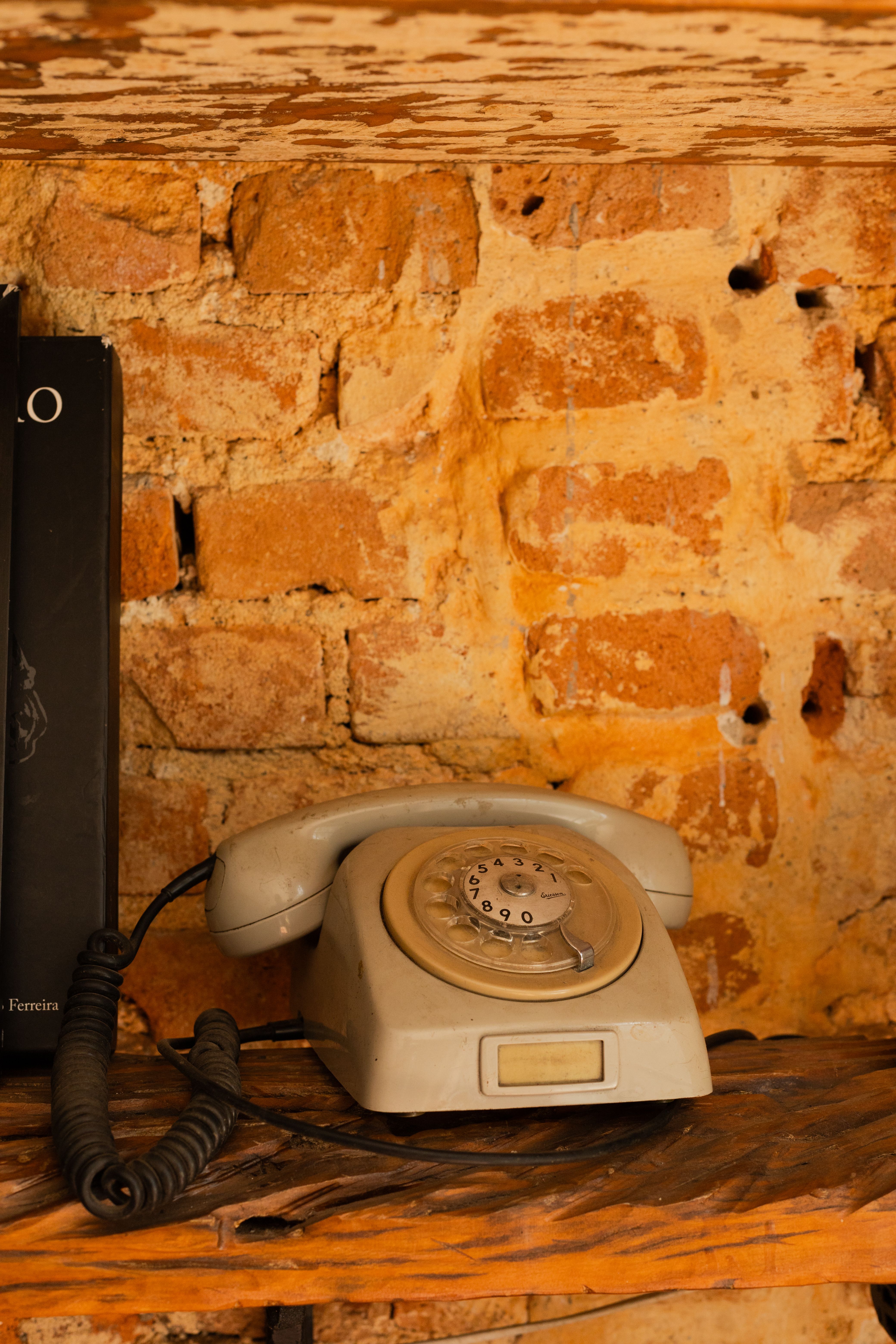 Vintage Rotary Telephone on Rustic Brick Wall · Free Stock Photo